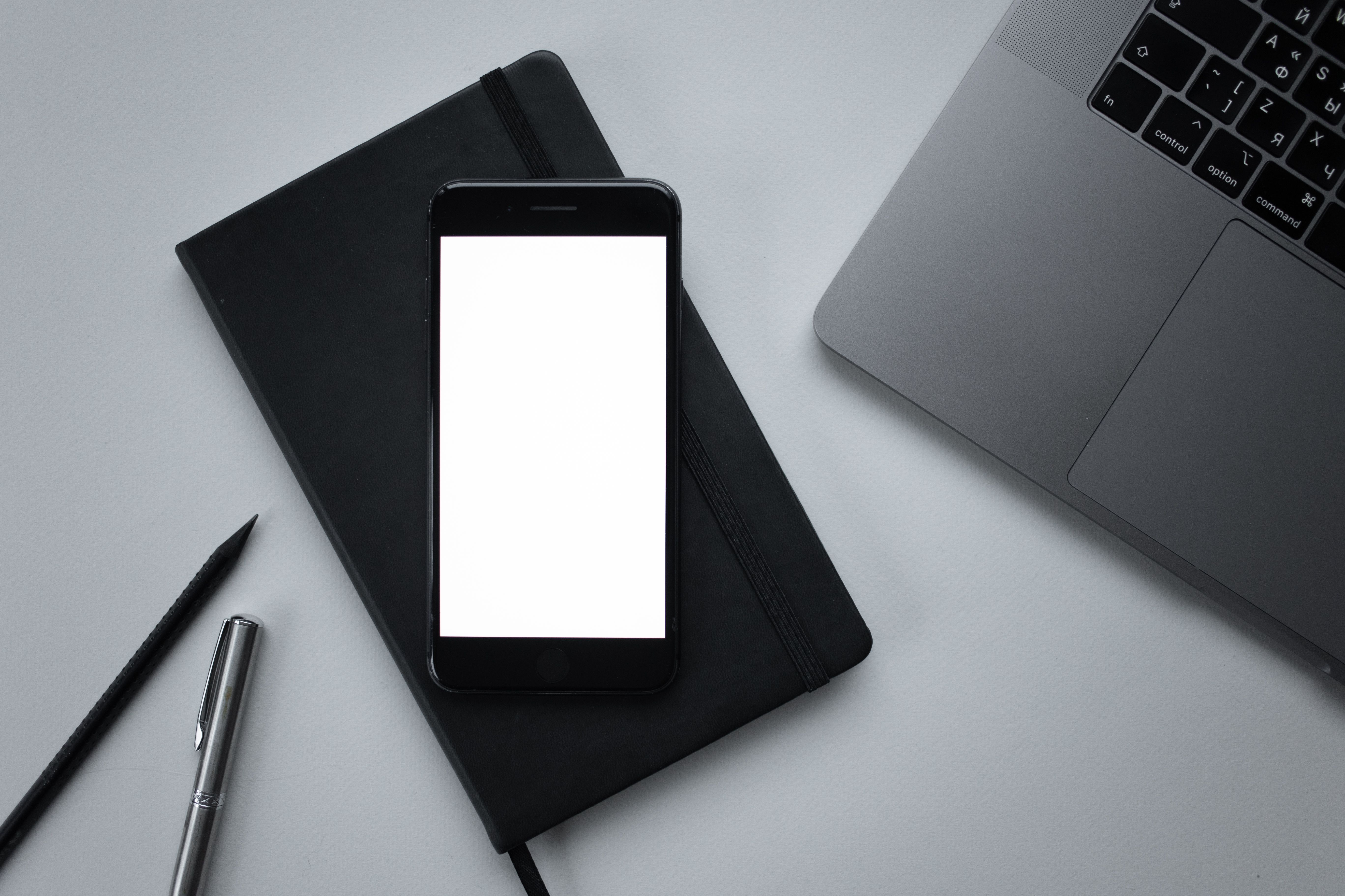 A Black Smartphone with Blank Screen on a Black Notebook · Free Stock Photo