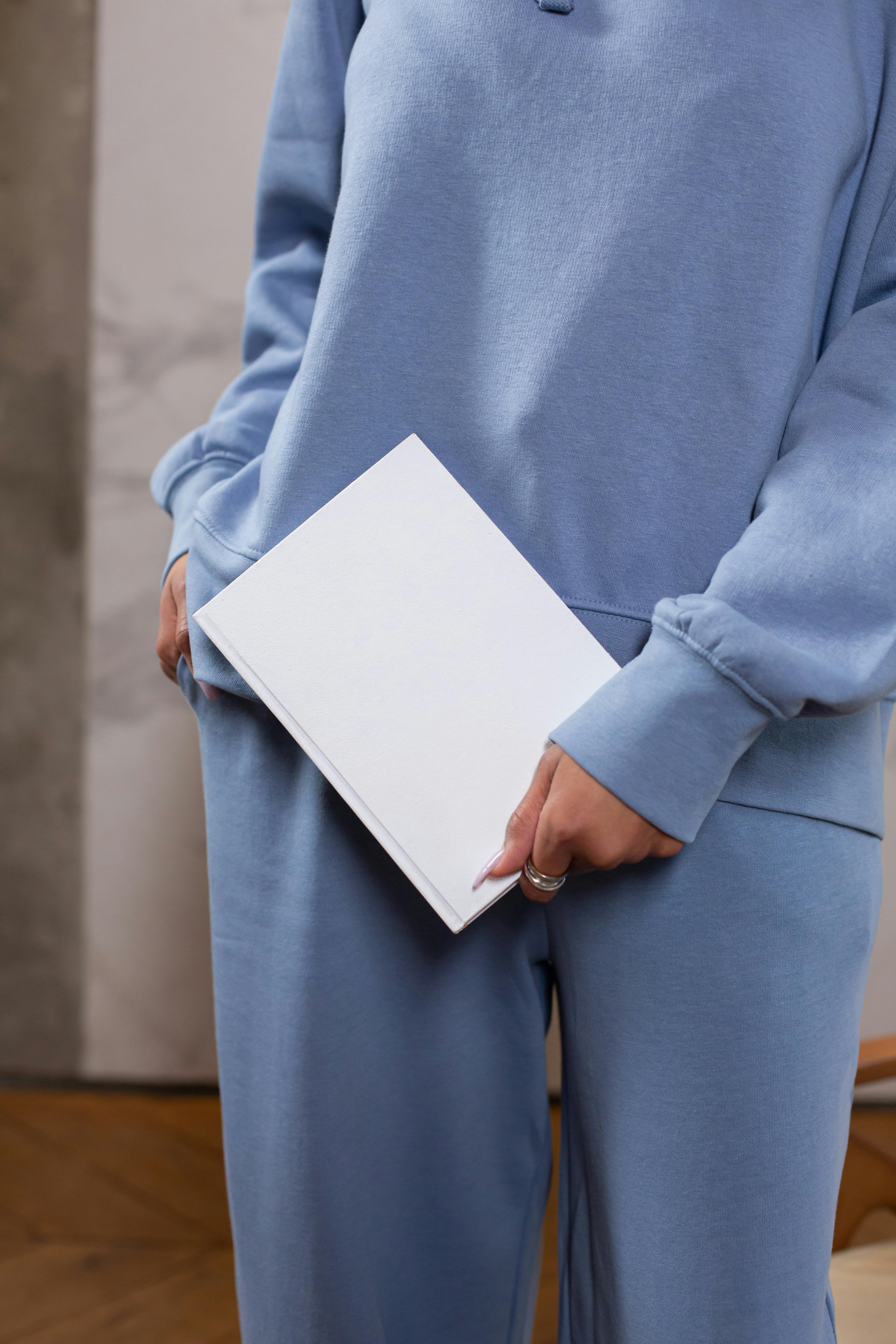 Woman in activewear holding blank notebook · Free Stock Photo