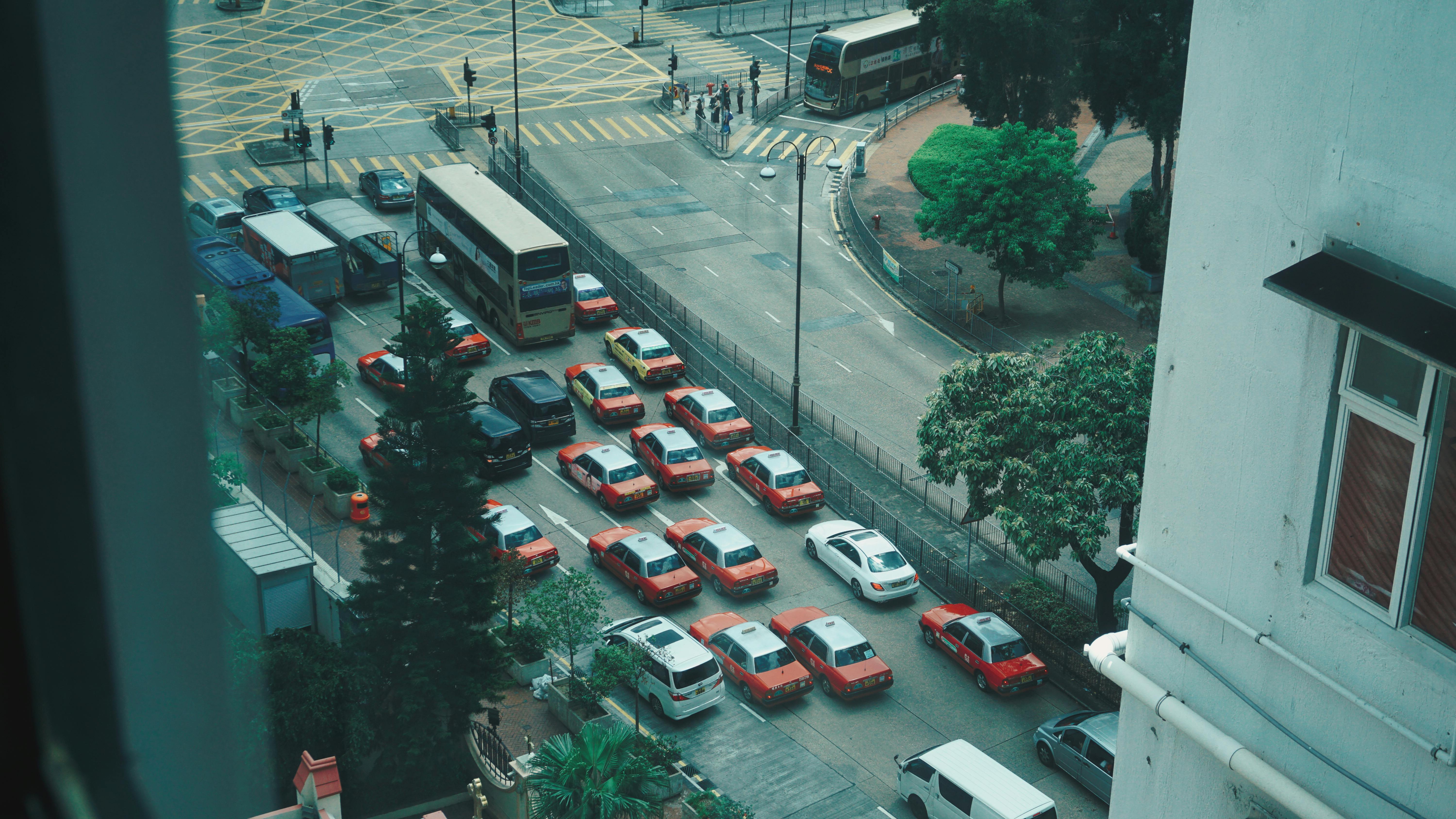 Red Vehicle on Road Beside Building · Free Stock Photo