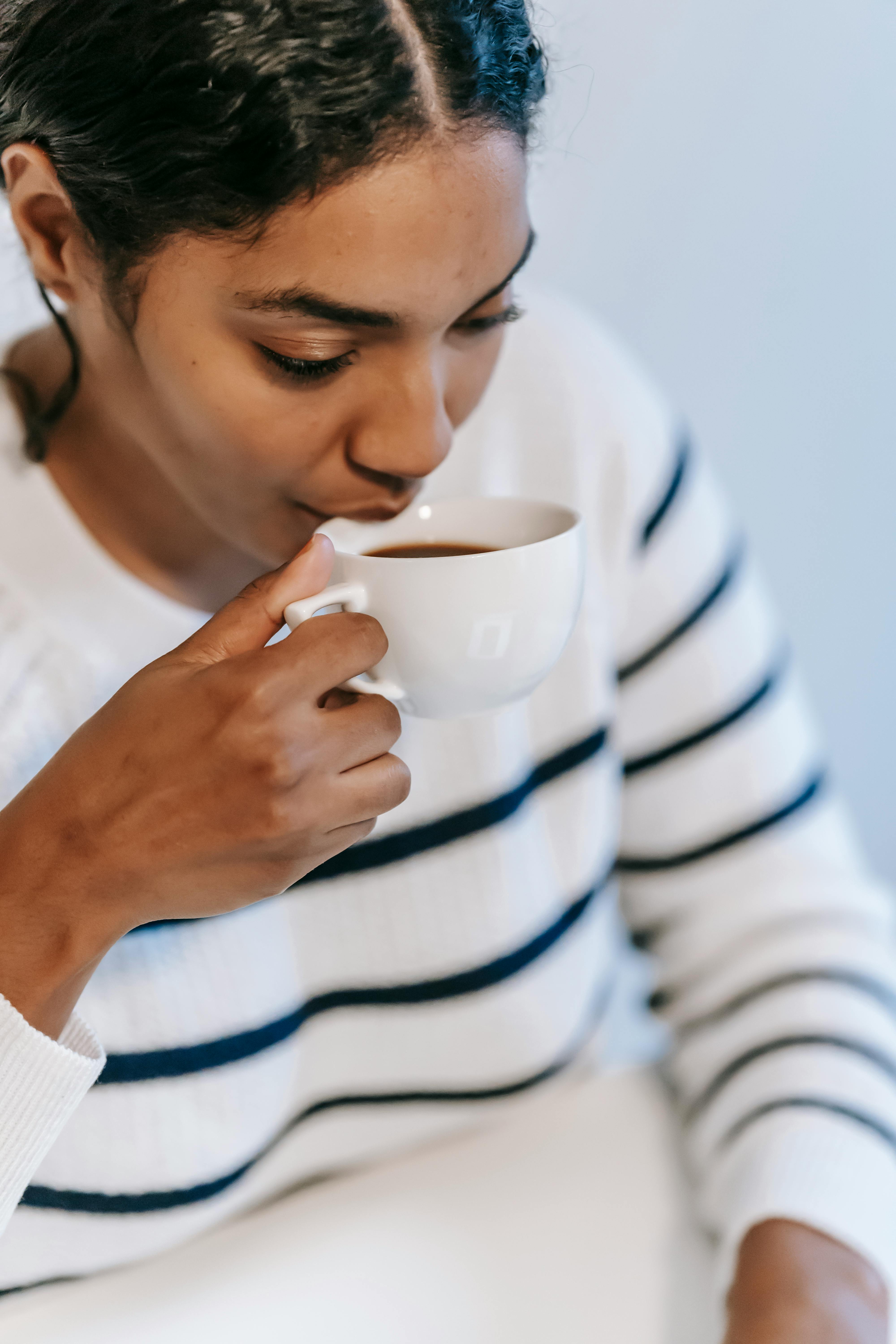 Indian woman drinking tea at table at home · Free Stock Photo