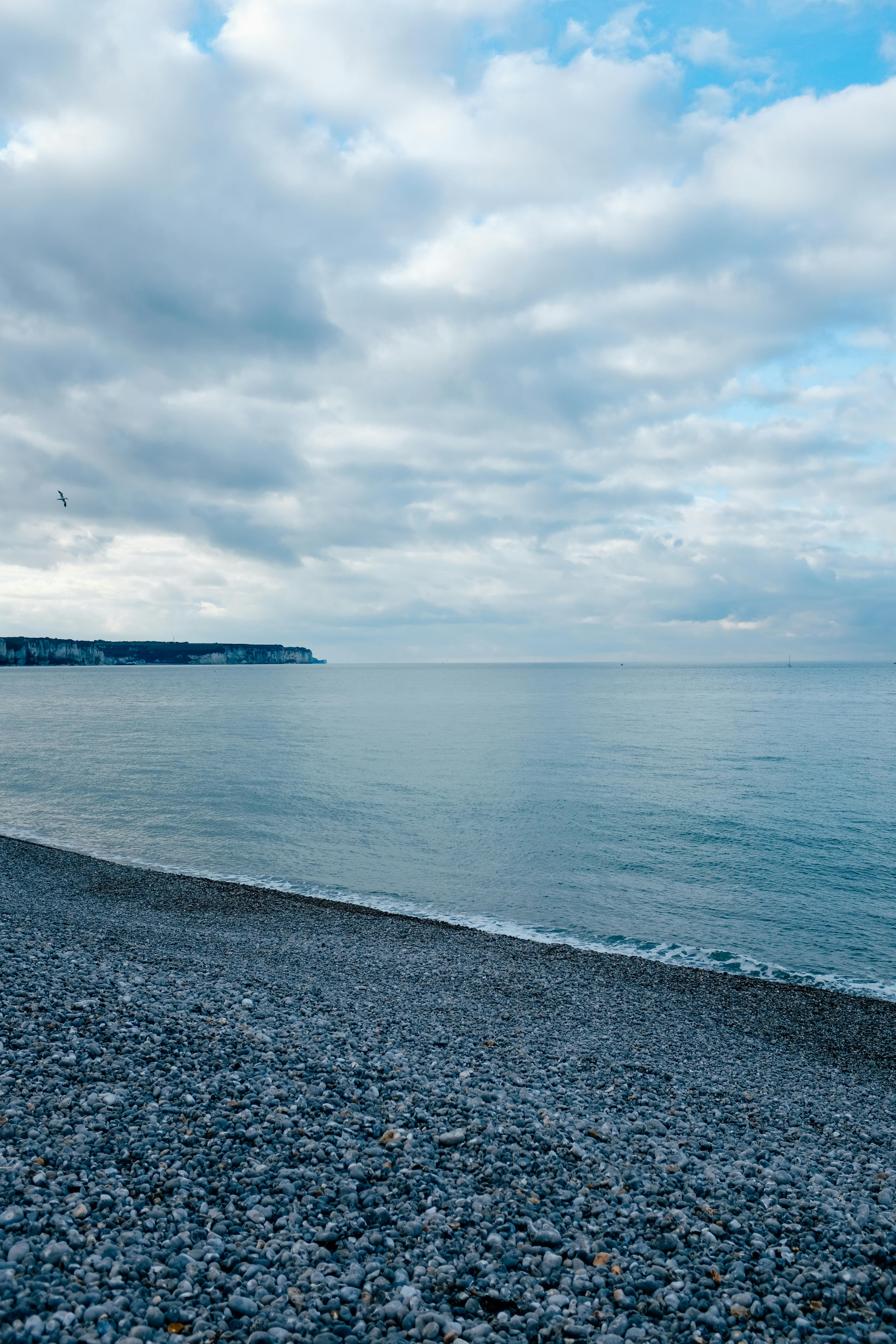 Peaceful sea with shore of stones · Free Stock Photo