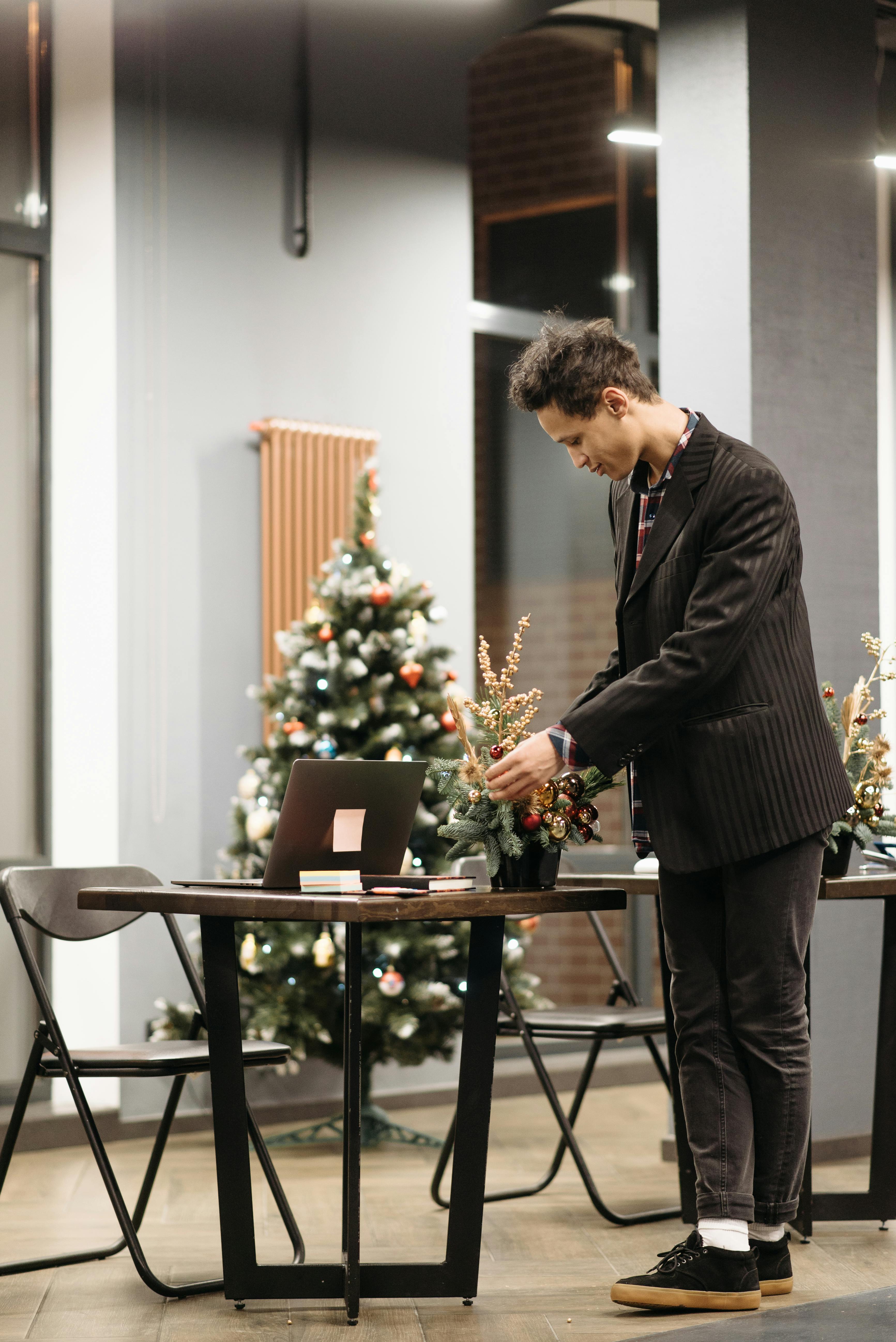 A Man Arranging Flowers in an Office · Free Stock Photo