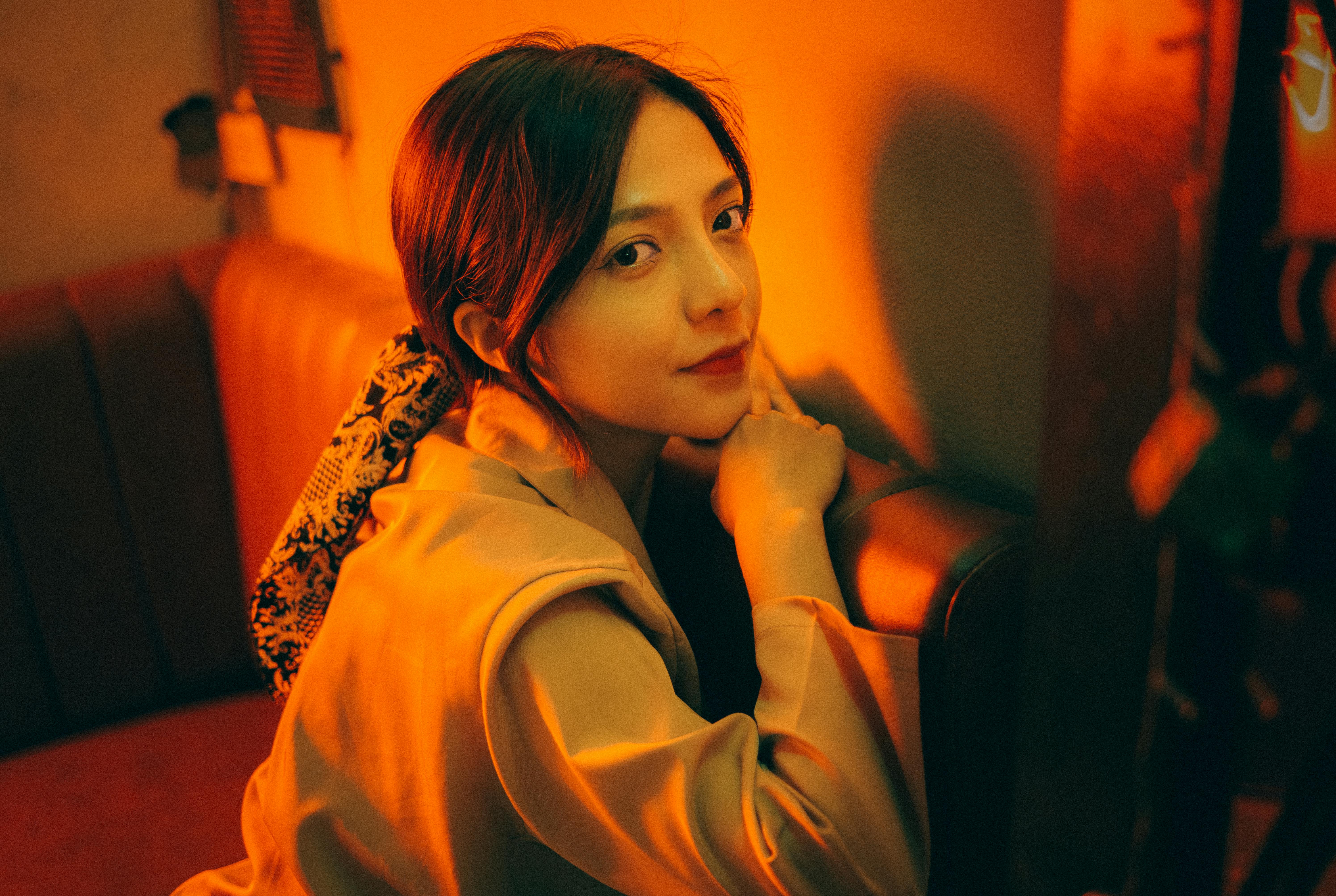 Charming Asian woman with sincere gaze resting on sofa · Free Stock Photo