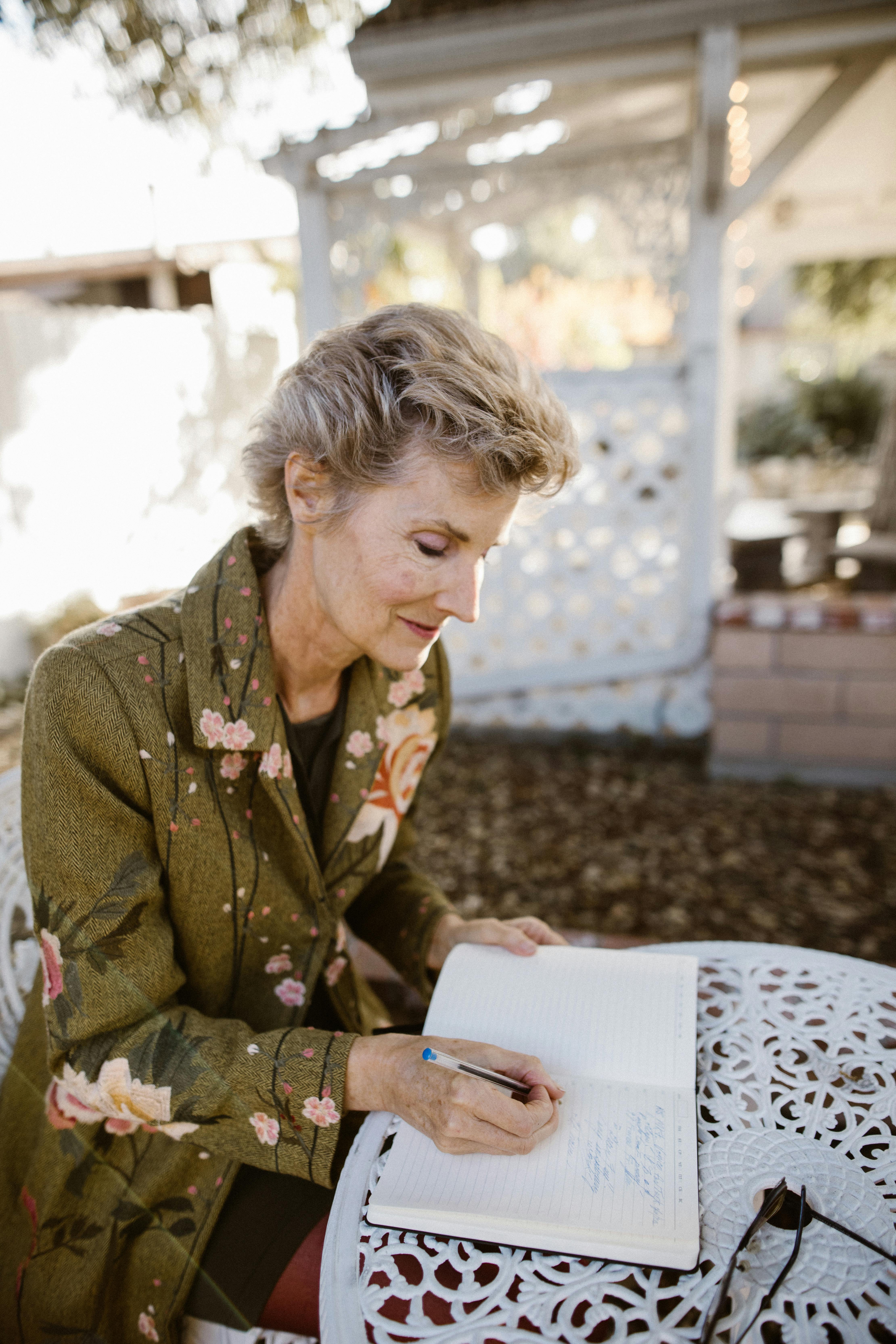 Concentrated senior man writing on notepad · Free Stock Photo