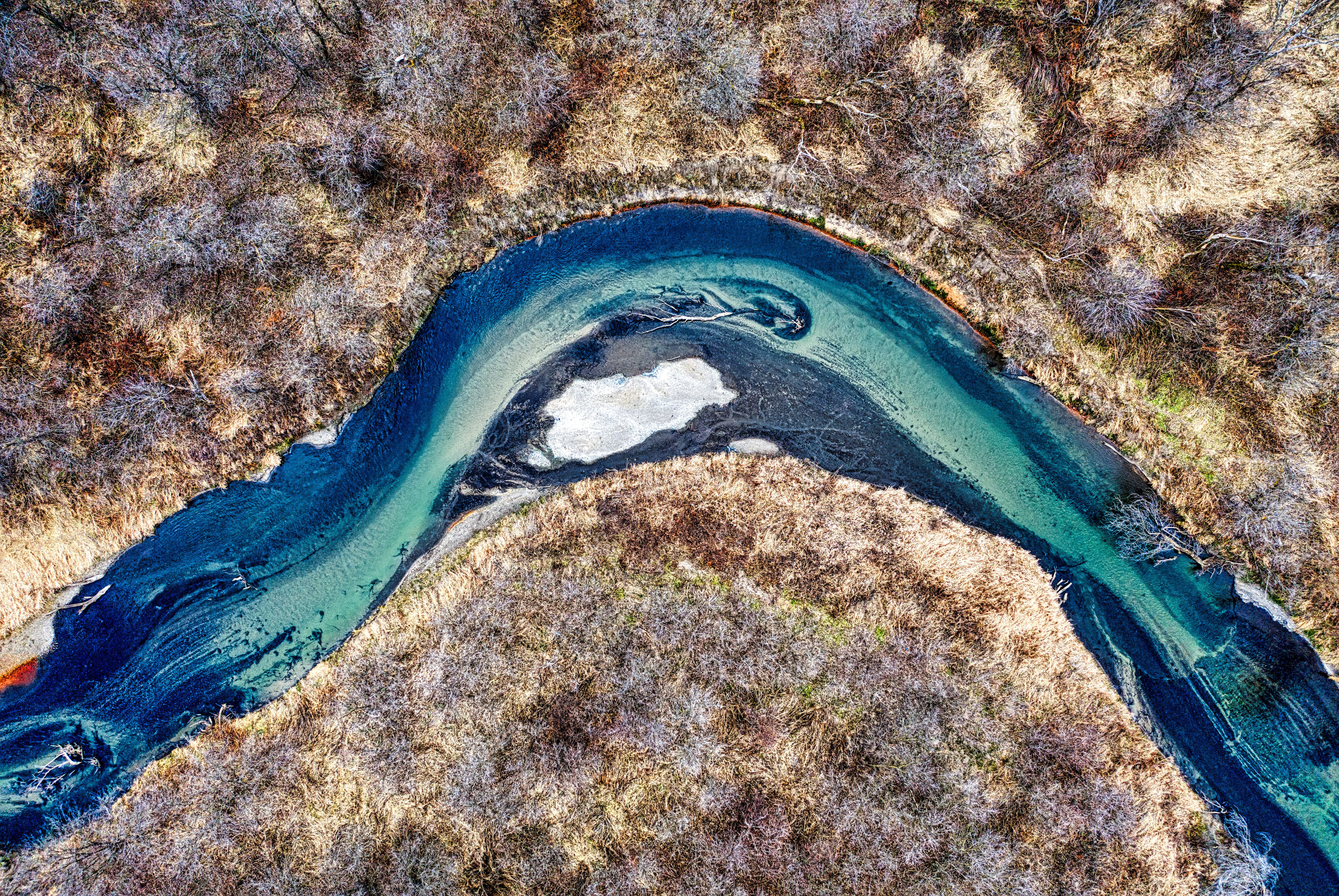 Narrow river flowing through grassy terrain · Free Stock Photo