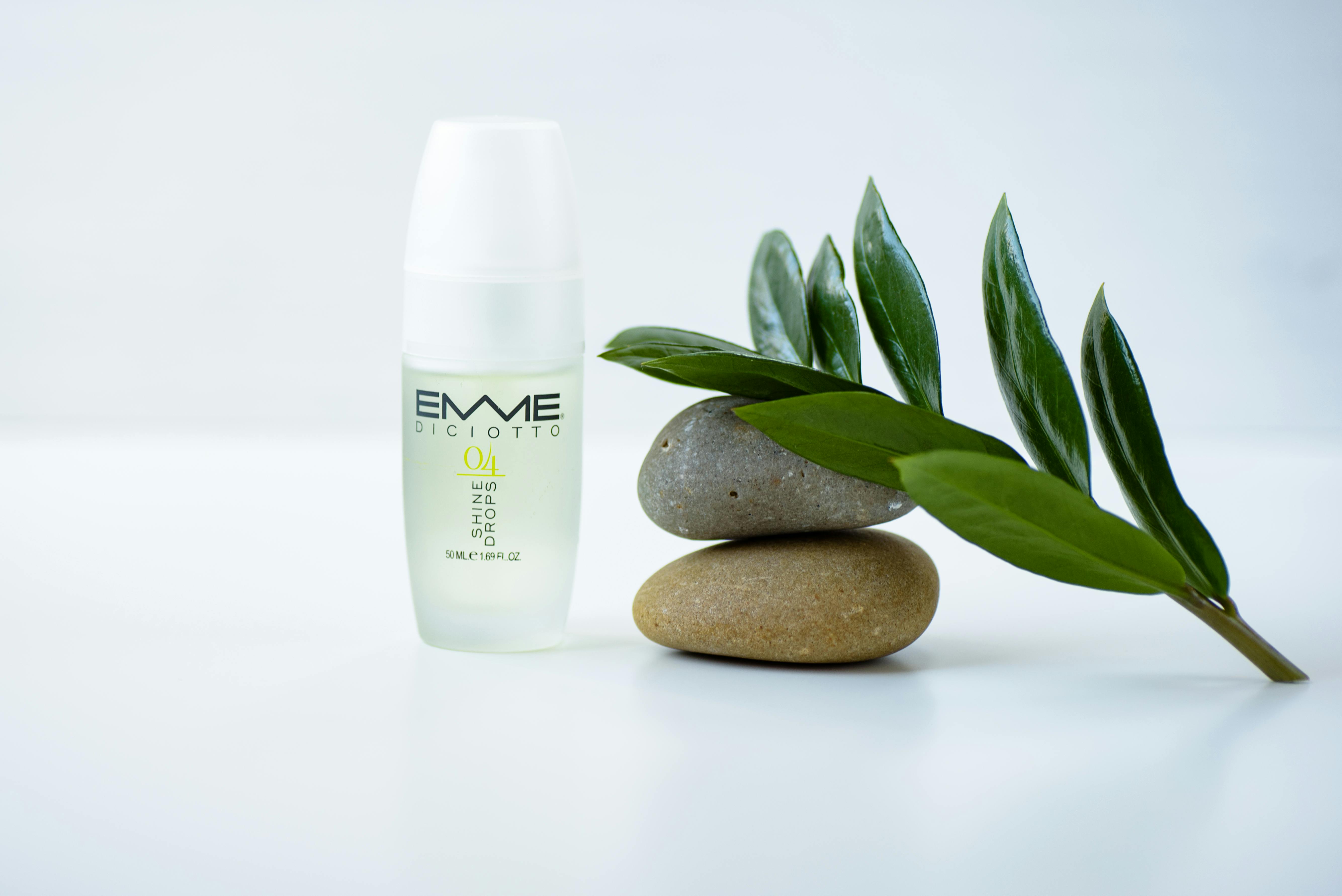 Shine Drops Serum Next to Stone and Leaves · Free Stock Photo