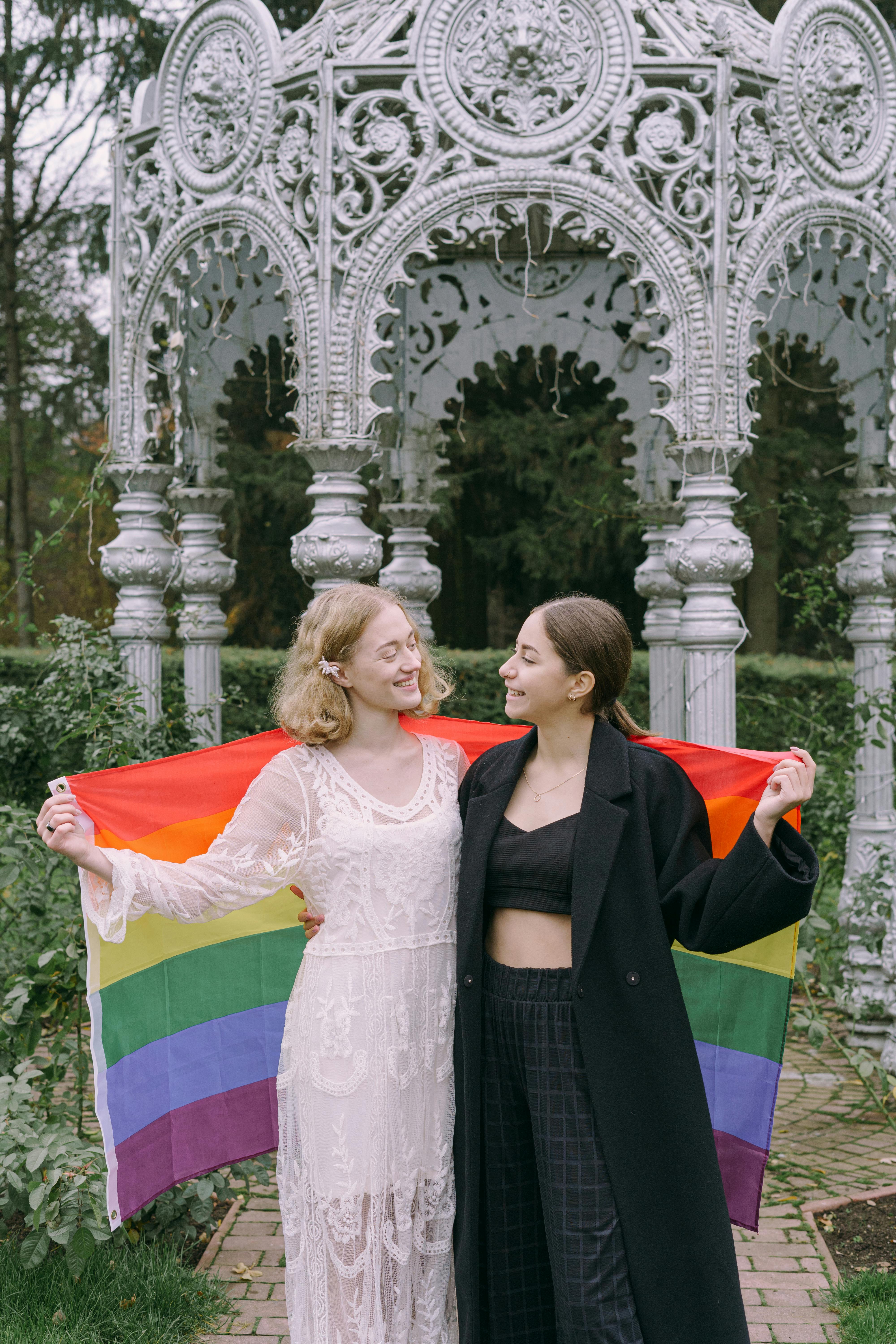 Couple Standing Together Holding Gay Pride Flag · Free Stock Photo