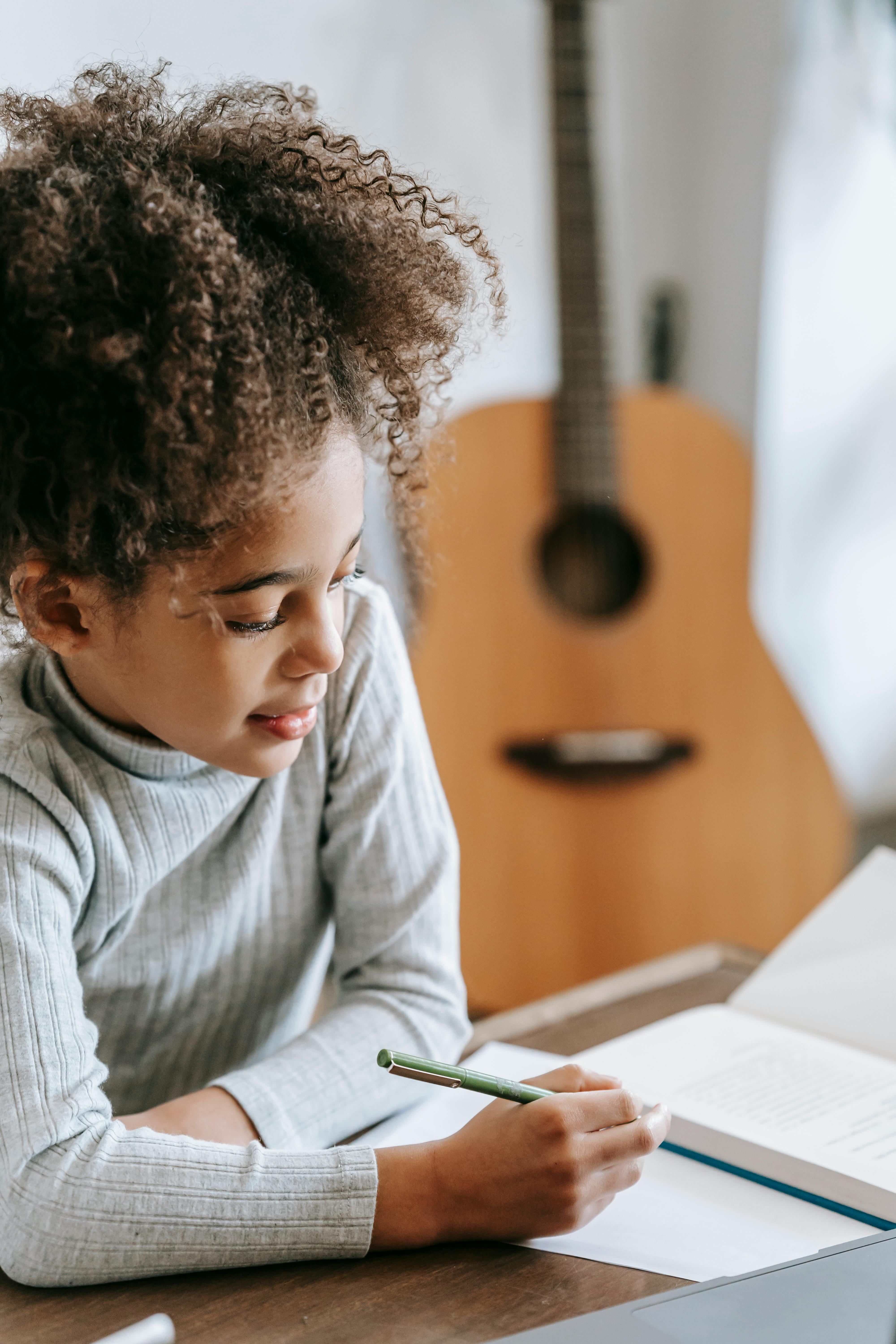 Focused black girl taking notes on paper · Free Stock Photo