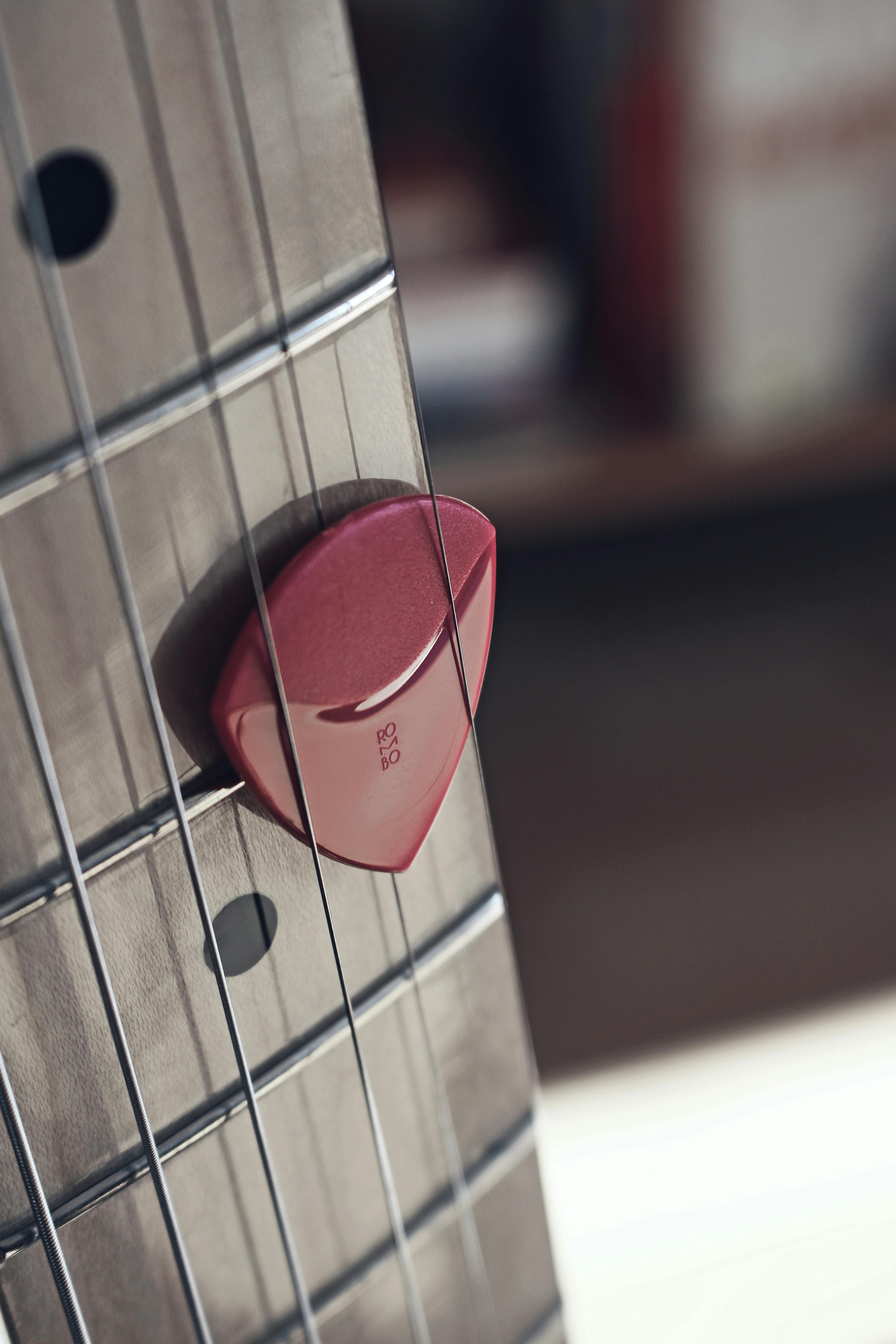 Red Guitar Pick on Brown Guitar String · Free Stock Photo