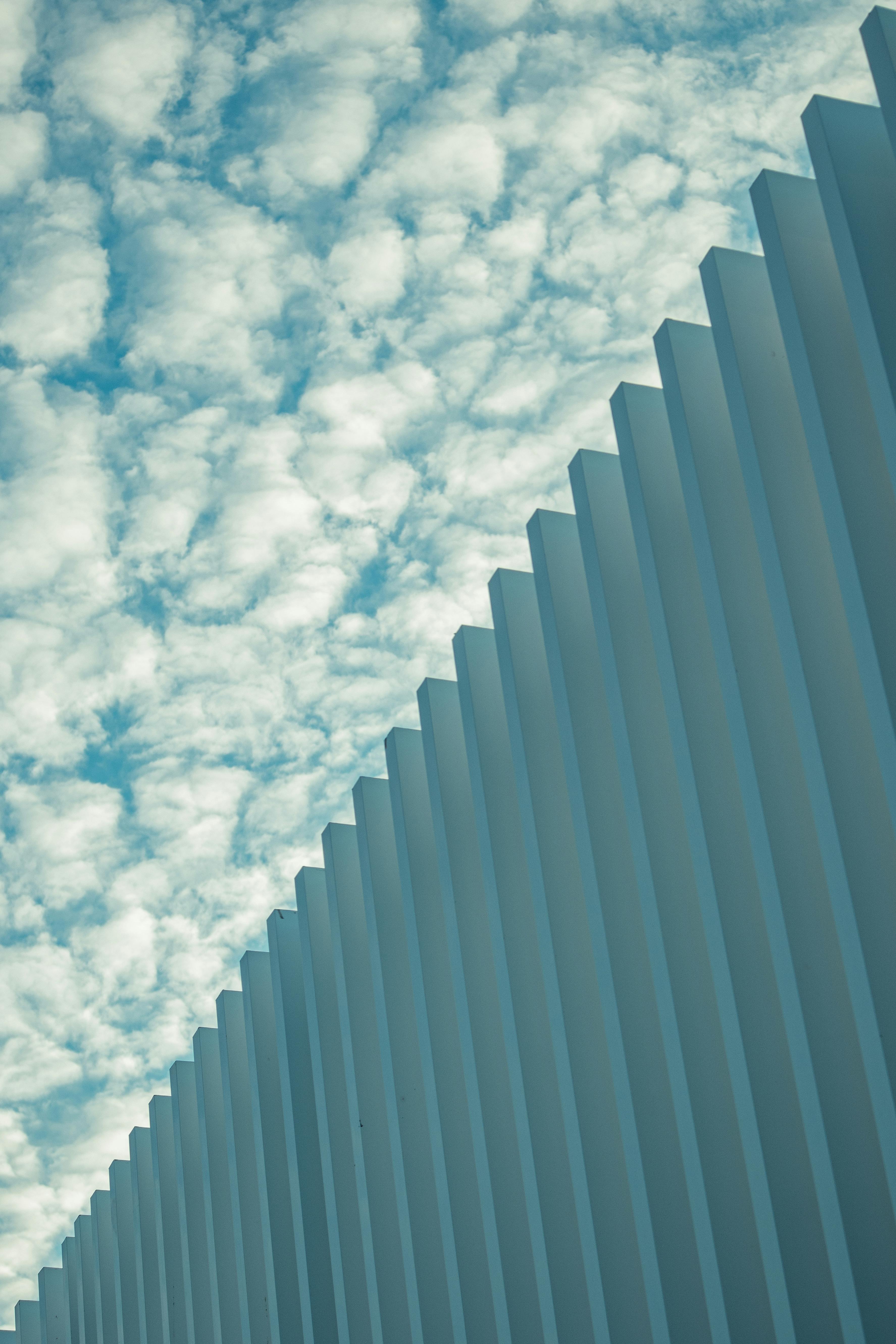 Blue Steel High Rise Fence Under Cloudy Sky · Free Stock Photo