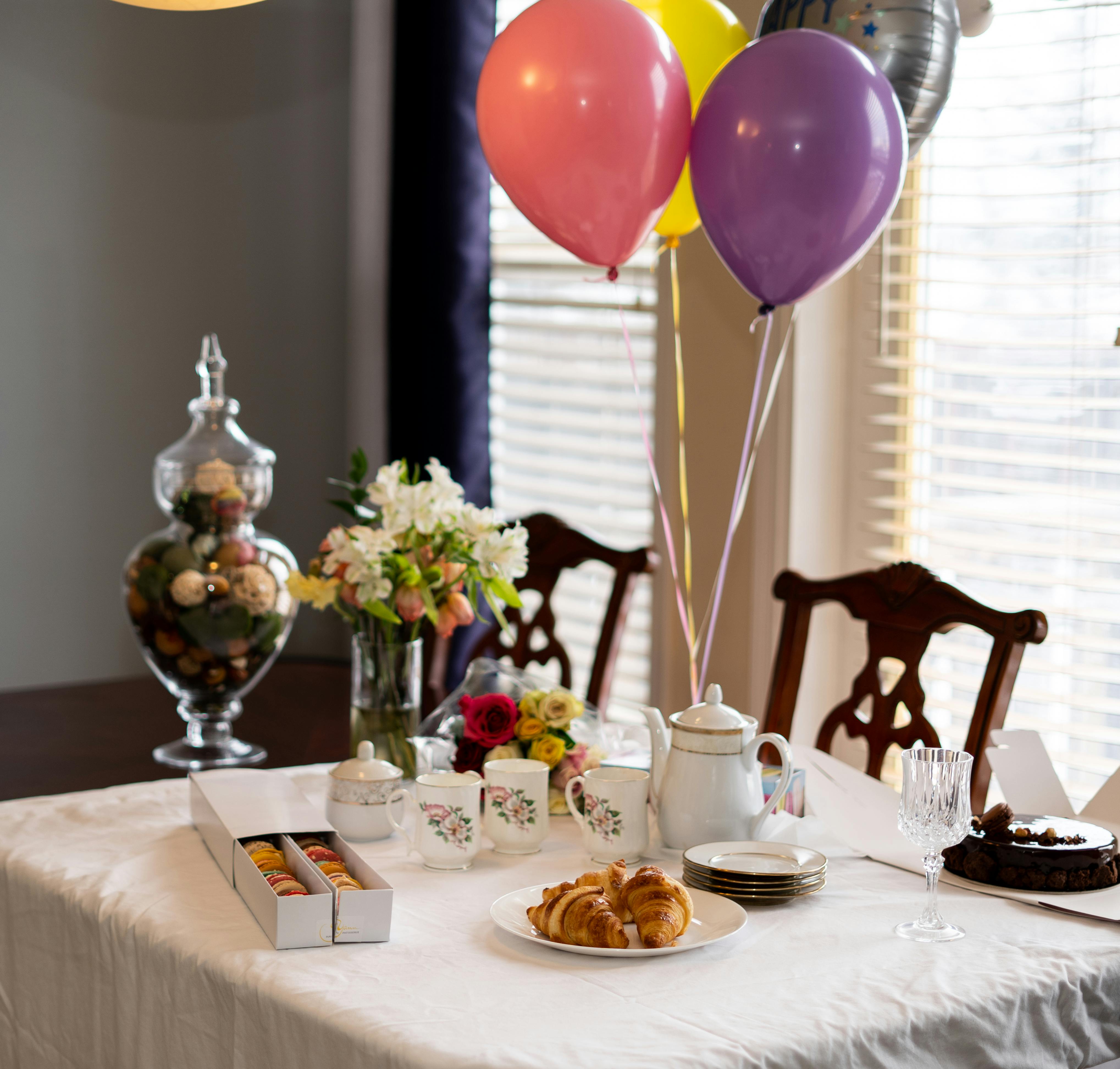 Colorful Balloons on Table With White Table Cloth · Free Stock Photo