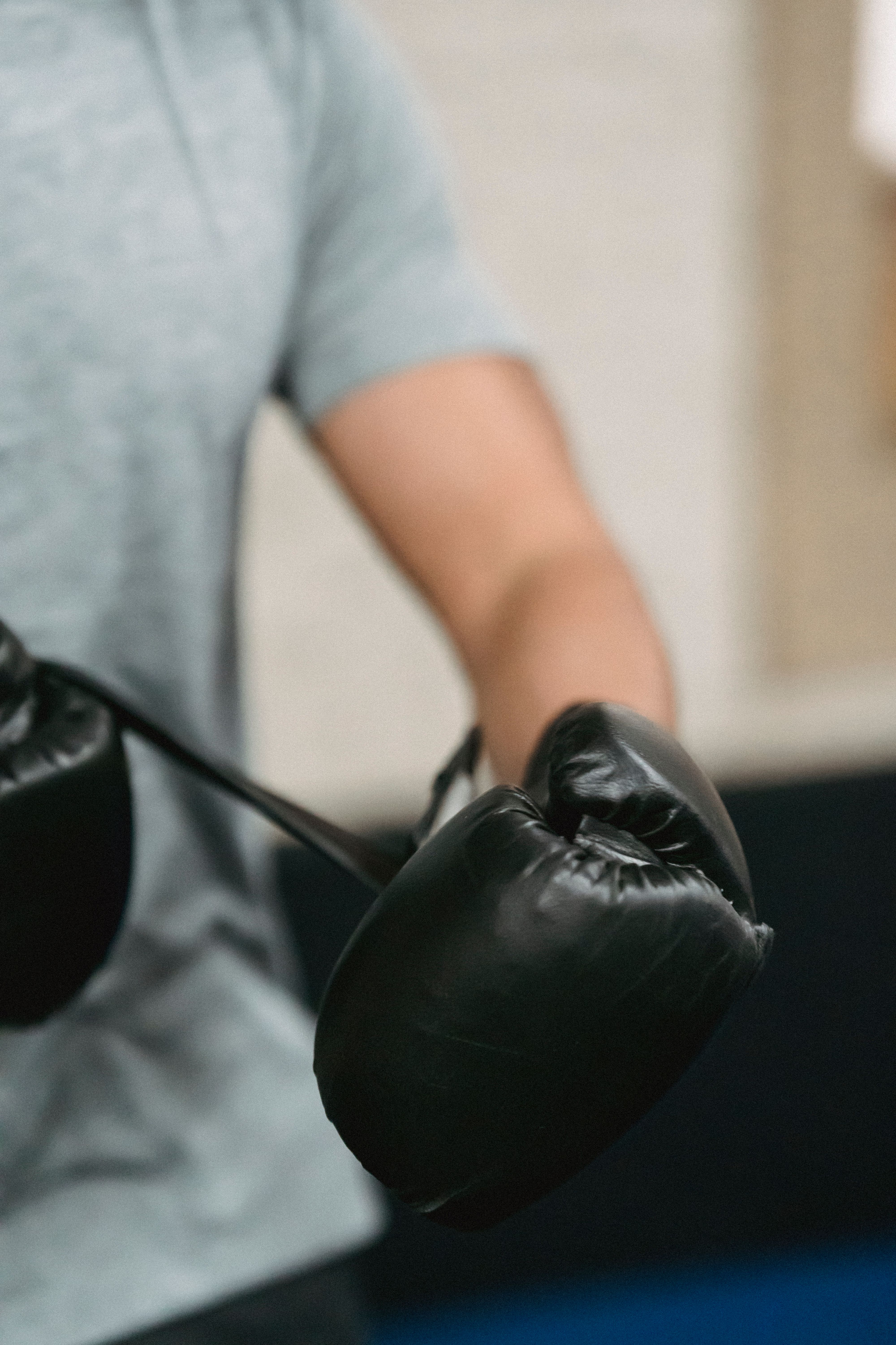 Crop sportsman putting on boxing gloves before training · Free Stock Photo