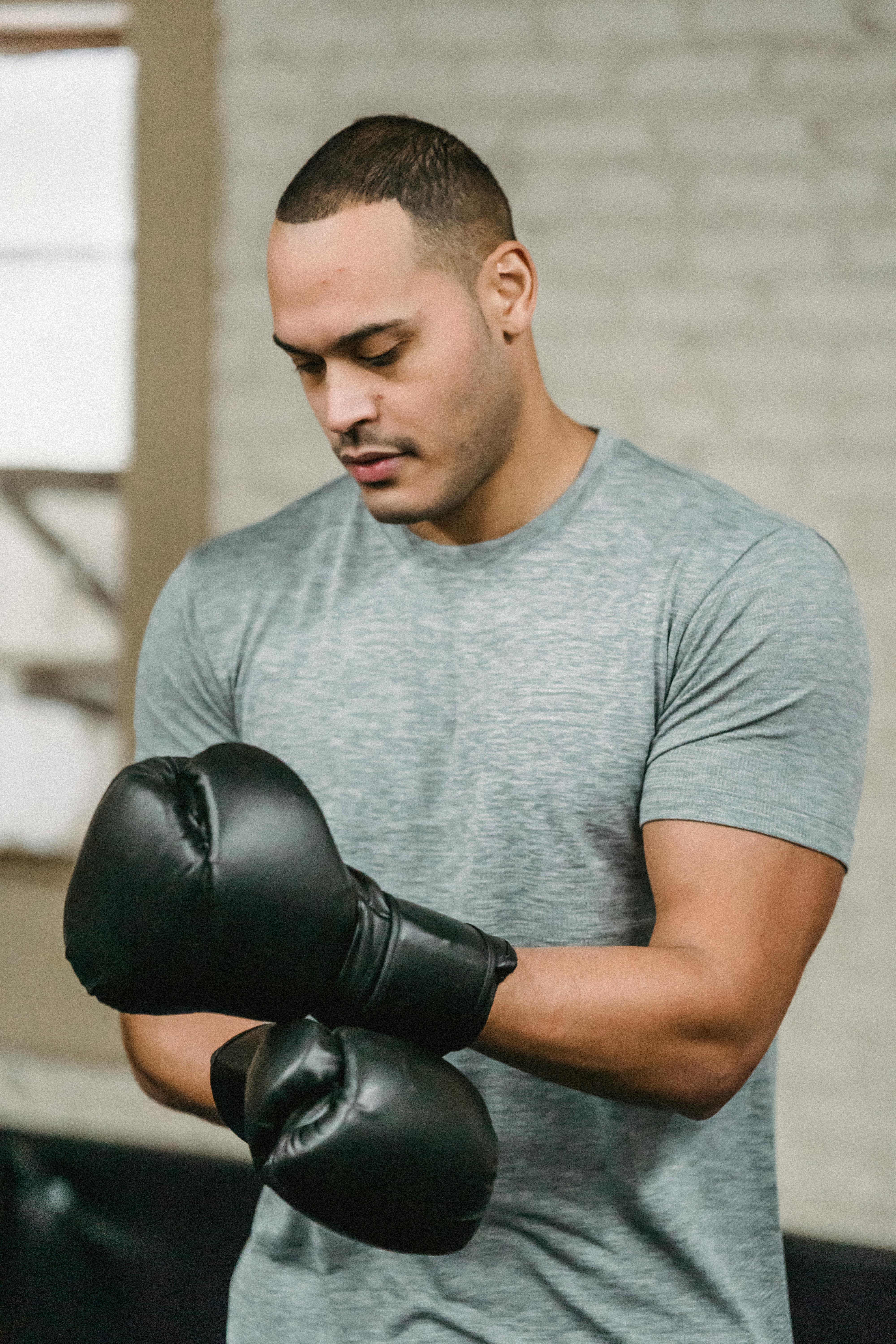 Strong ethnic boxer in sportswear before training in gym · Free Stock Photo