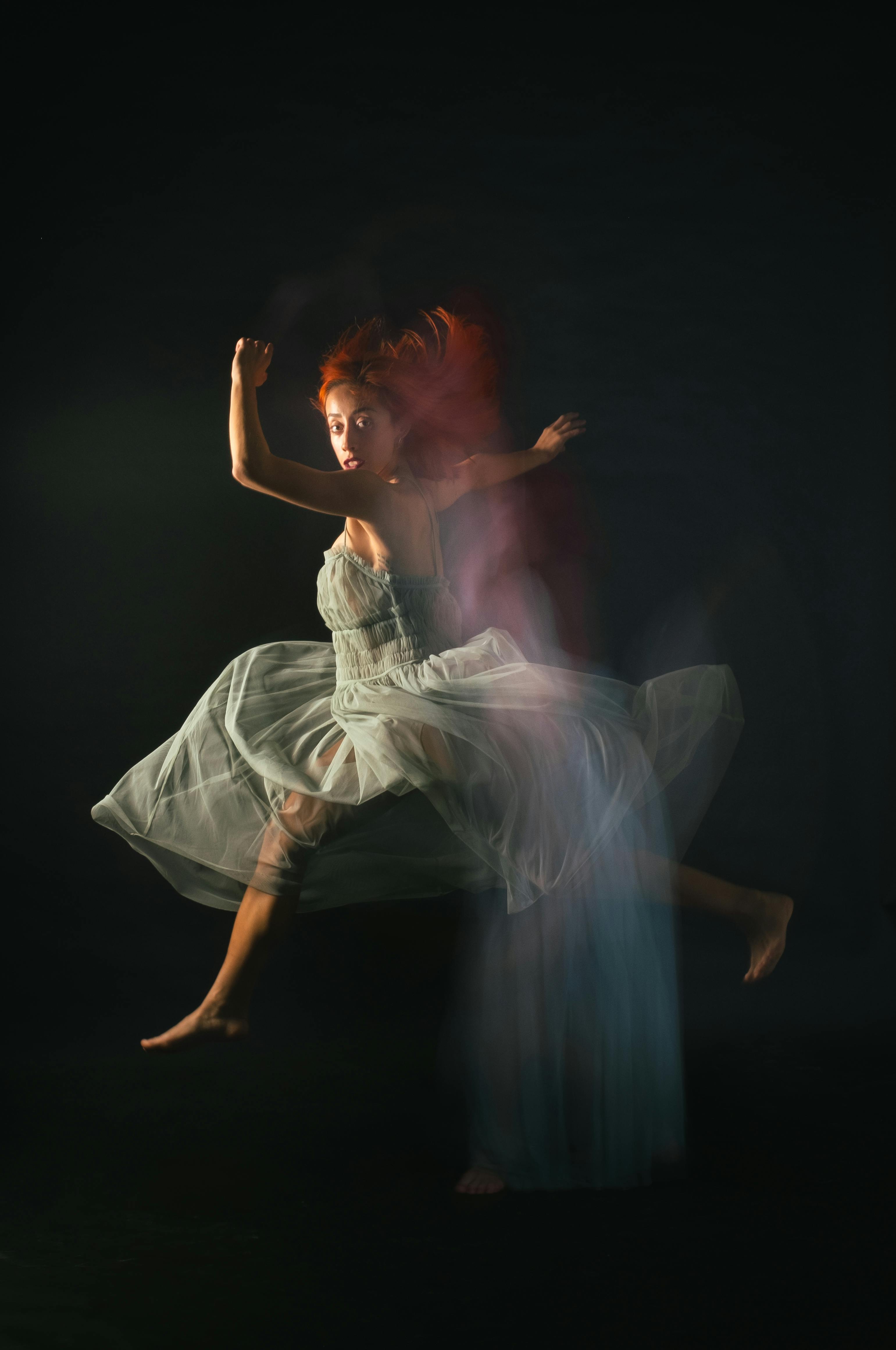 Black female dancer squatting with wooden stick at night · Free Stock Photo