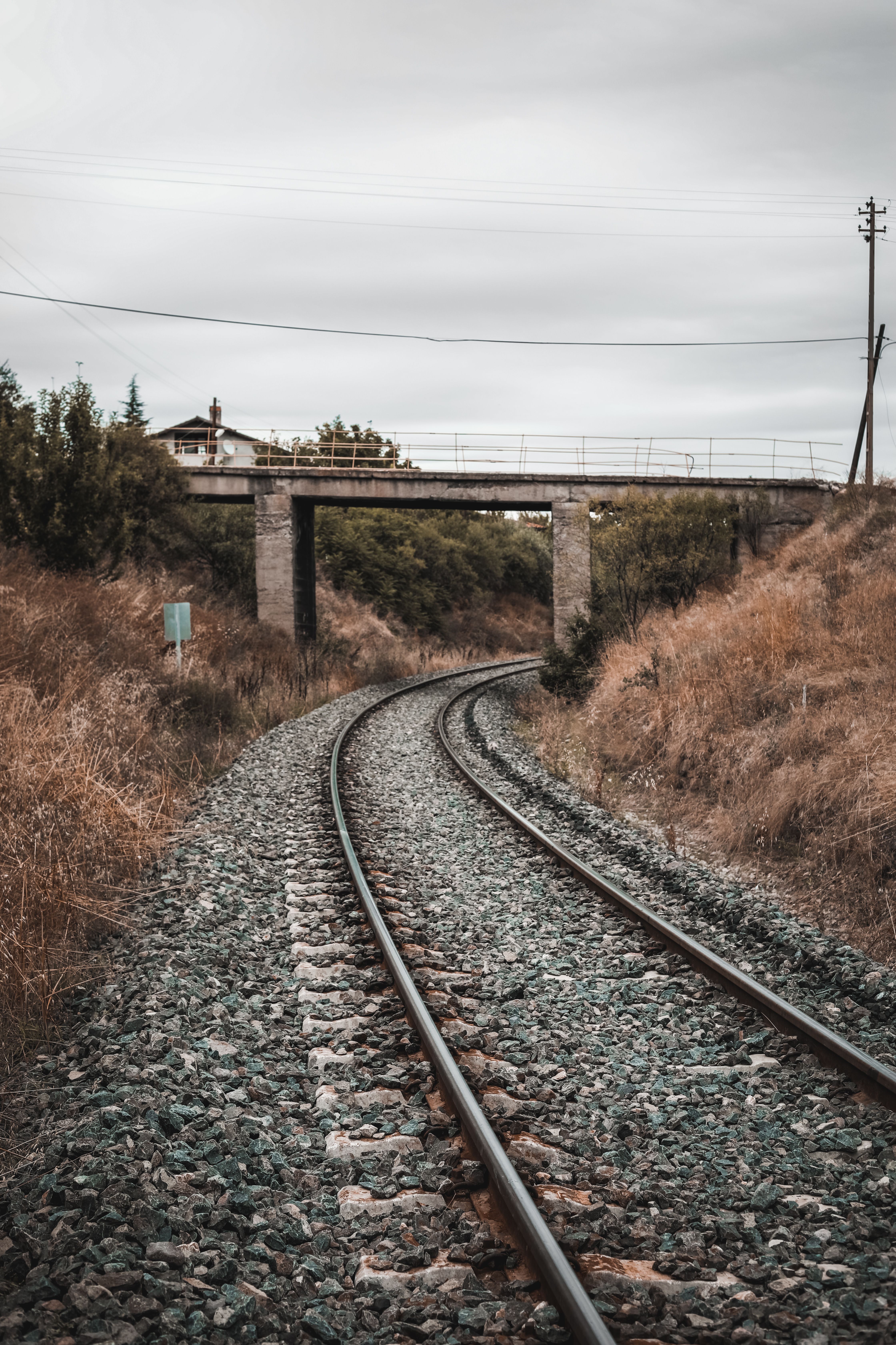 Aged bridge over railroad tracks in countryside on foggy day · Free ...