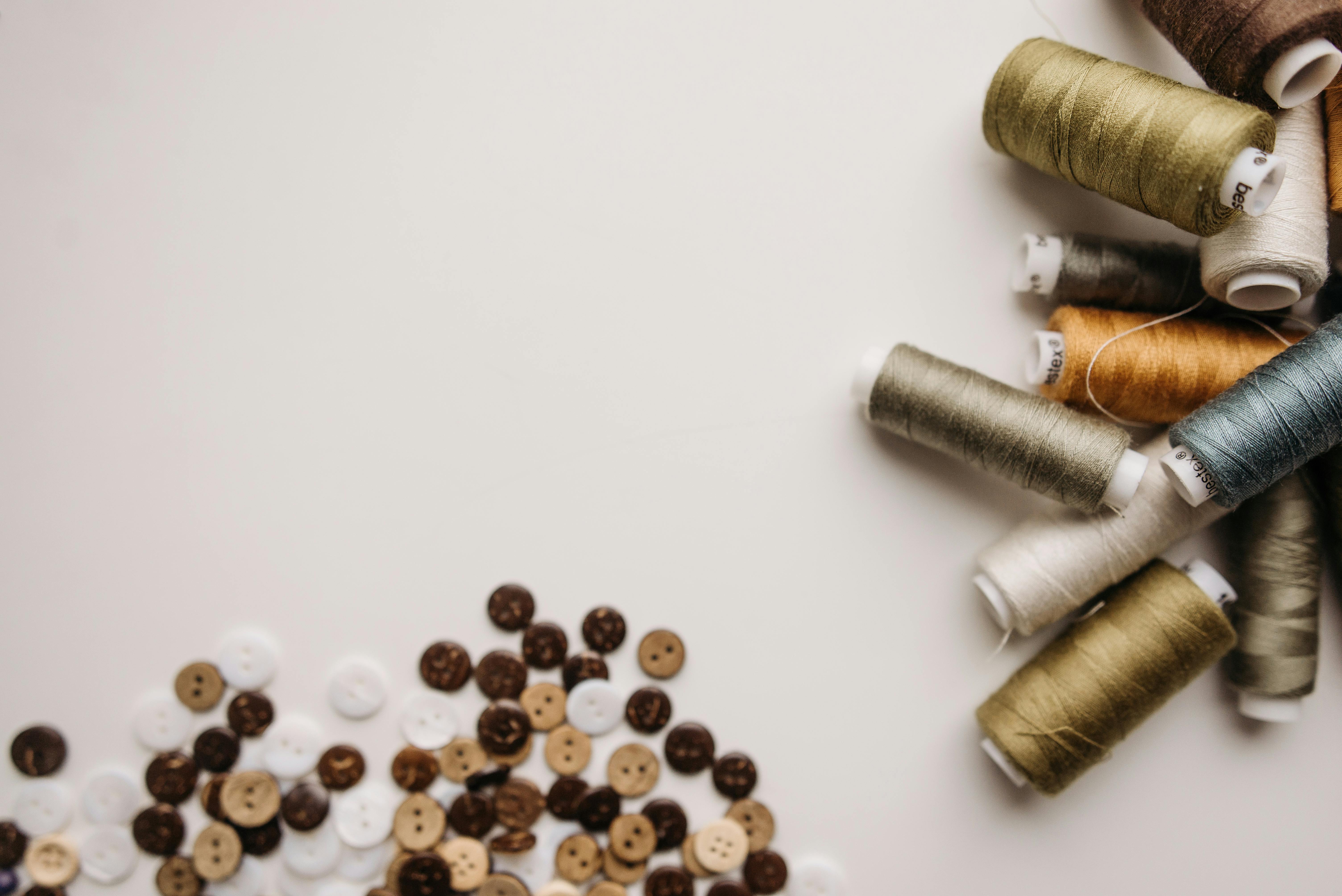 Sewing Threads on a White Surface · Free Stock Photo