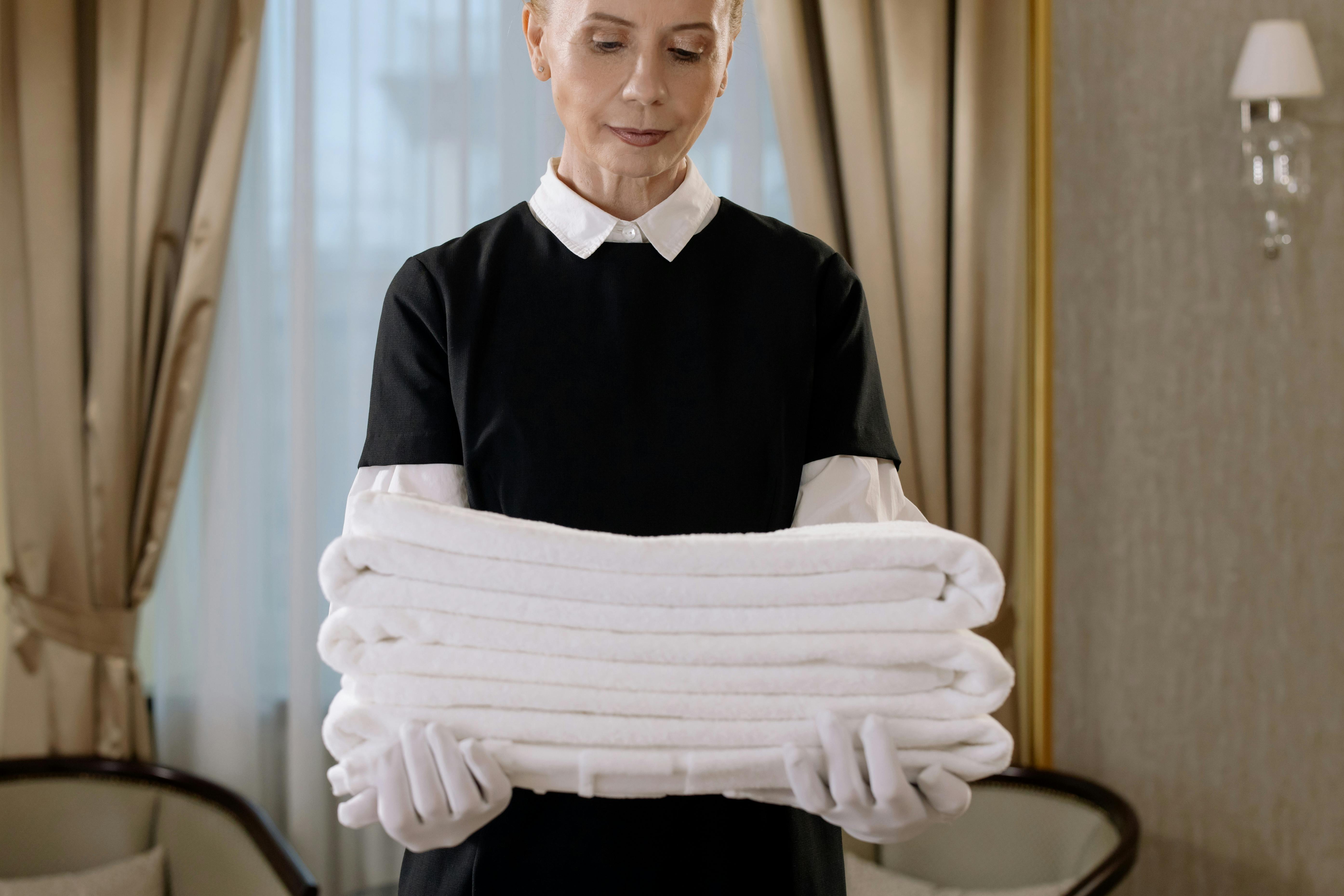 Ethnic male maid arranging hotel room · Free Stock Photo