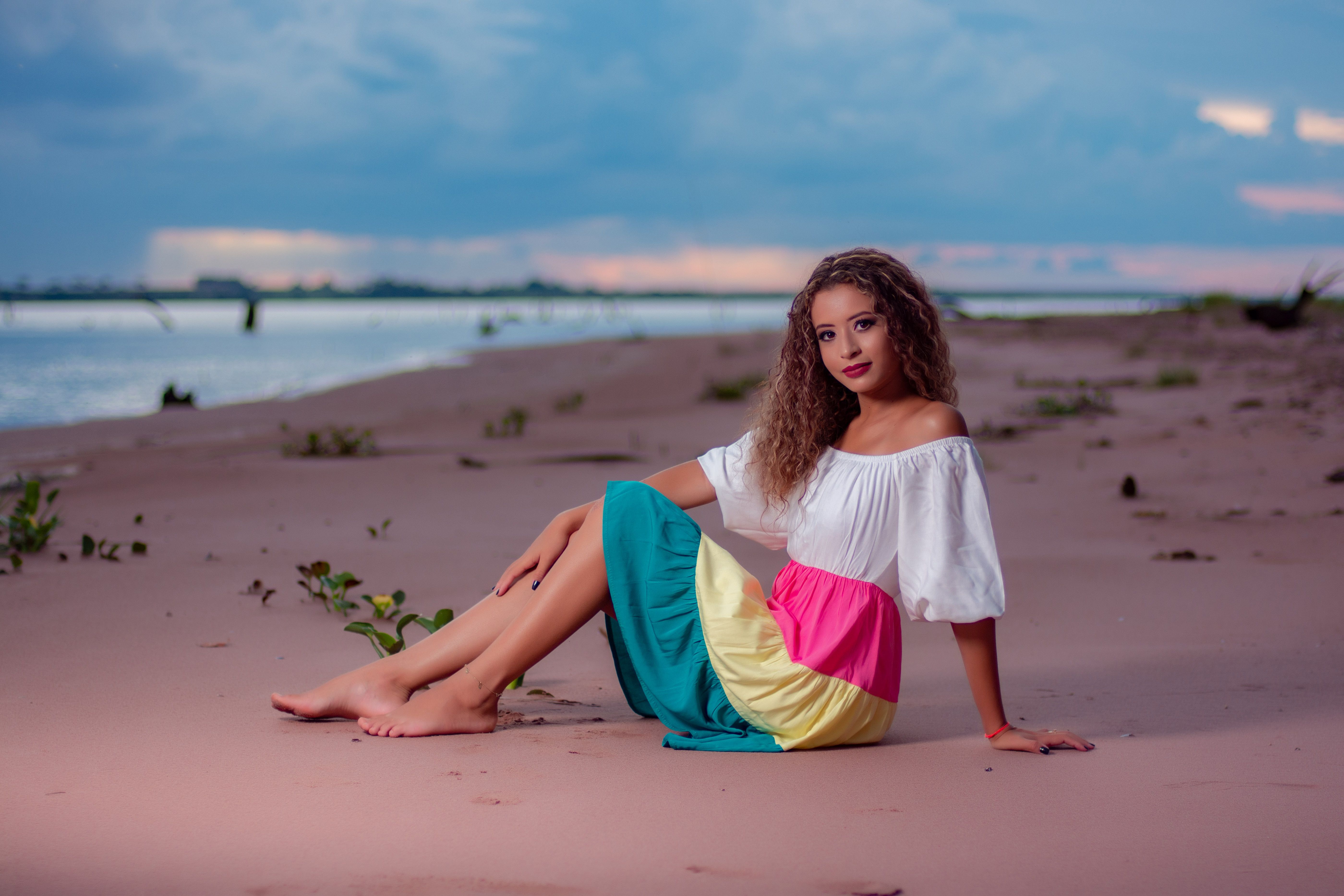 Woman Sitting on Seashore at Daytime · Free Stock Photo