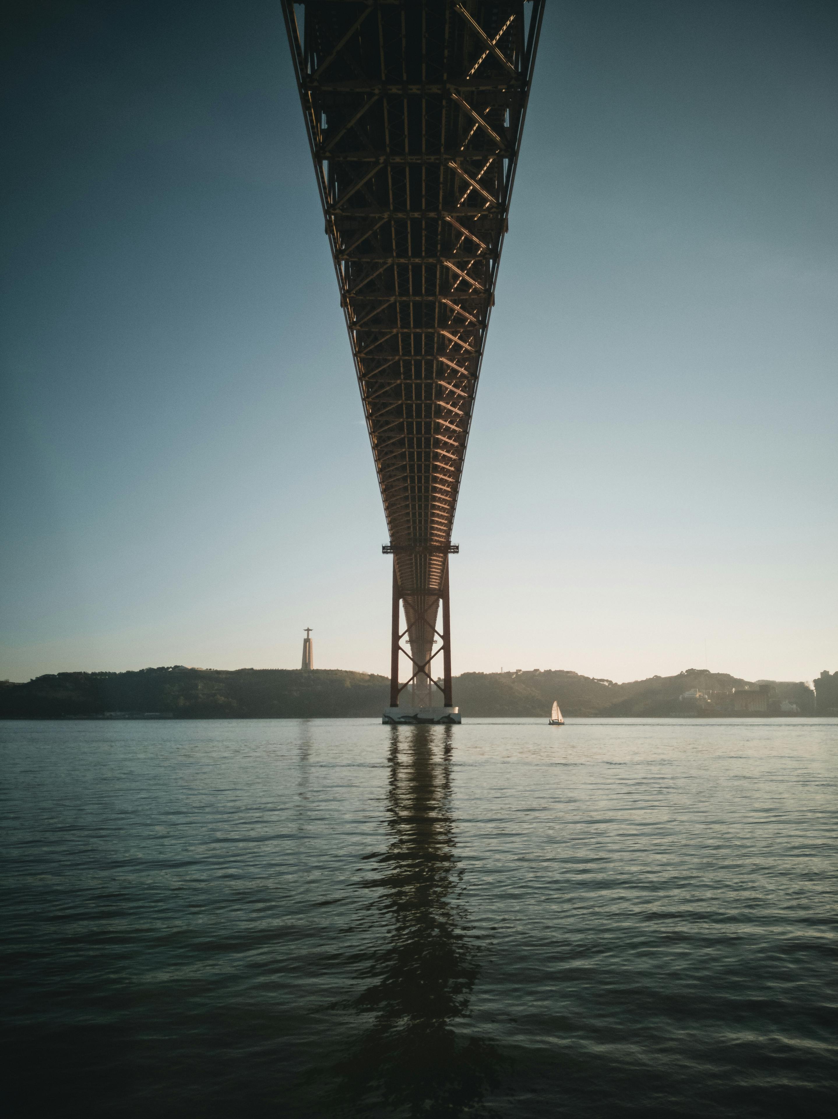Bridge over vast rippling river in countryside · Free Stock Photo