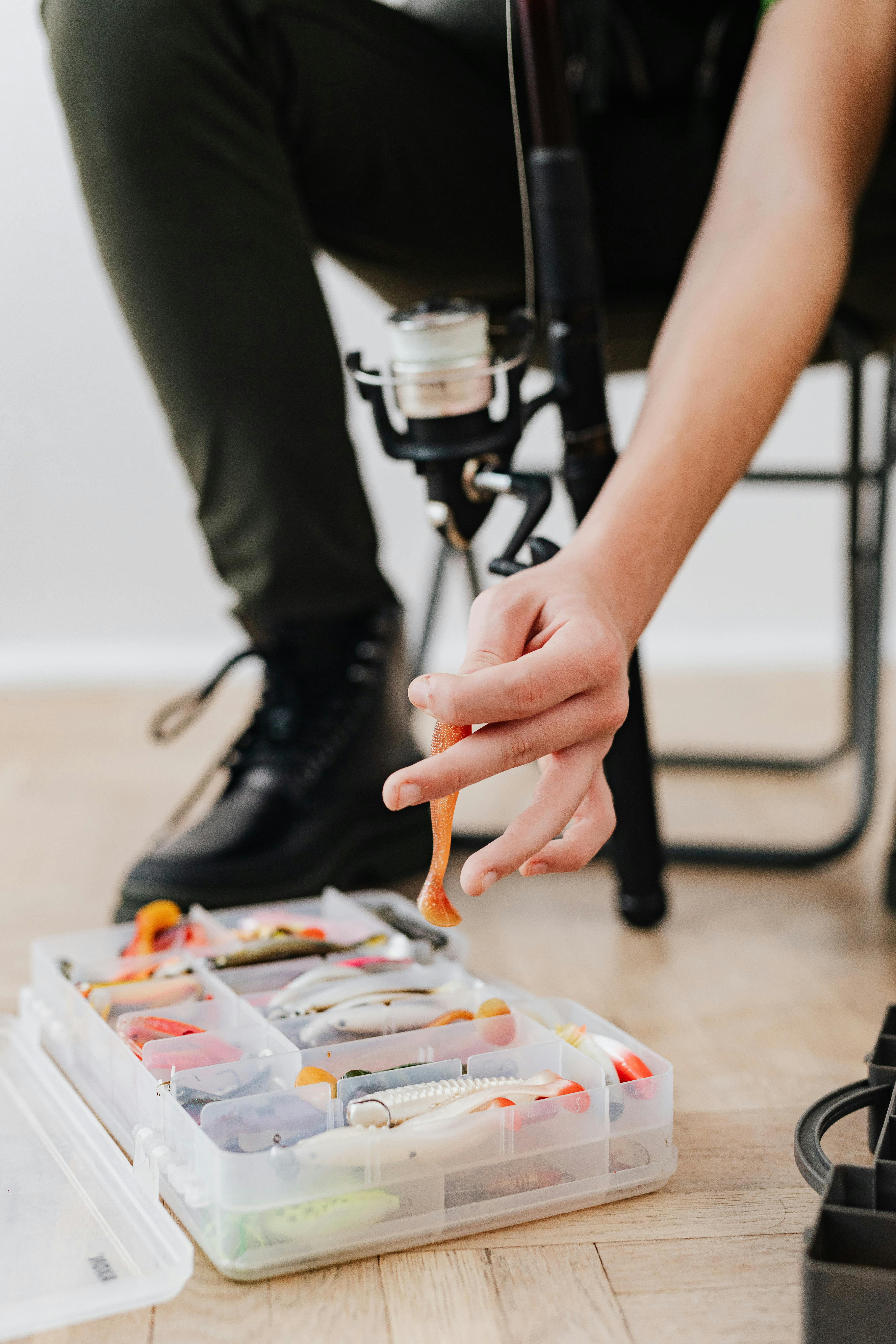 Person Taking a Fishing Lure from a Plastic Container · Free Stock Photo