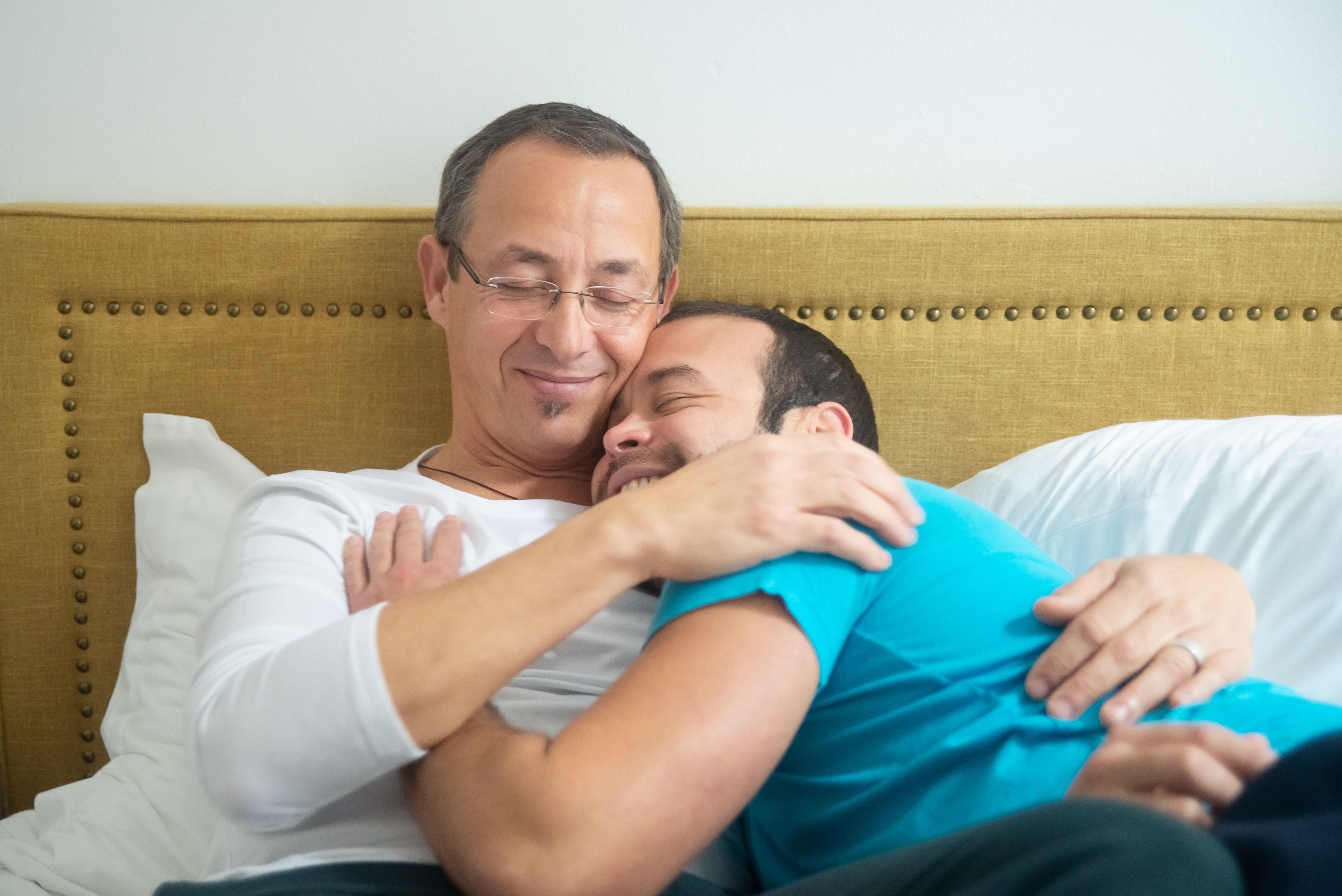 Man in White Long Sleeve Shirt Hugging Man in Teal Shirt · Free Stock Photo