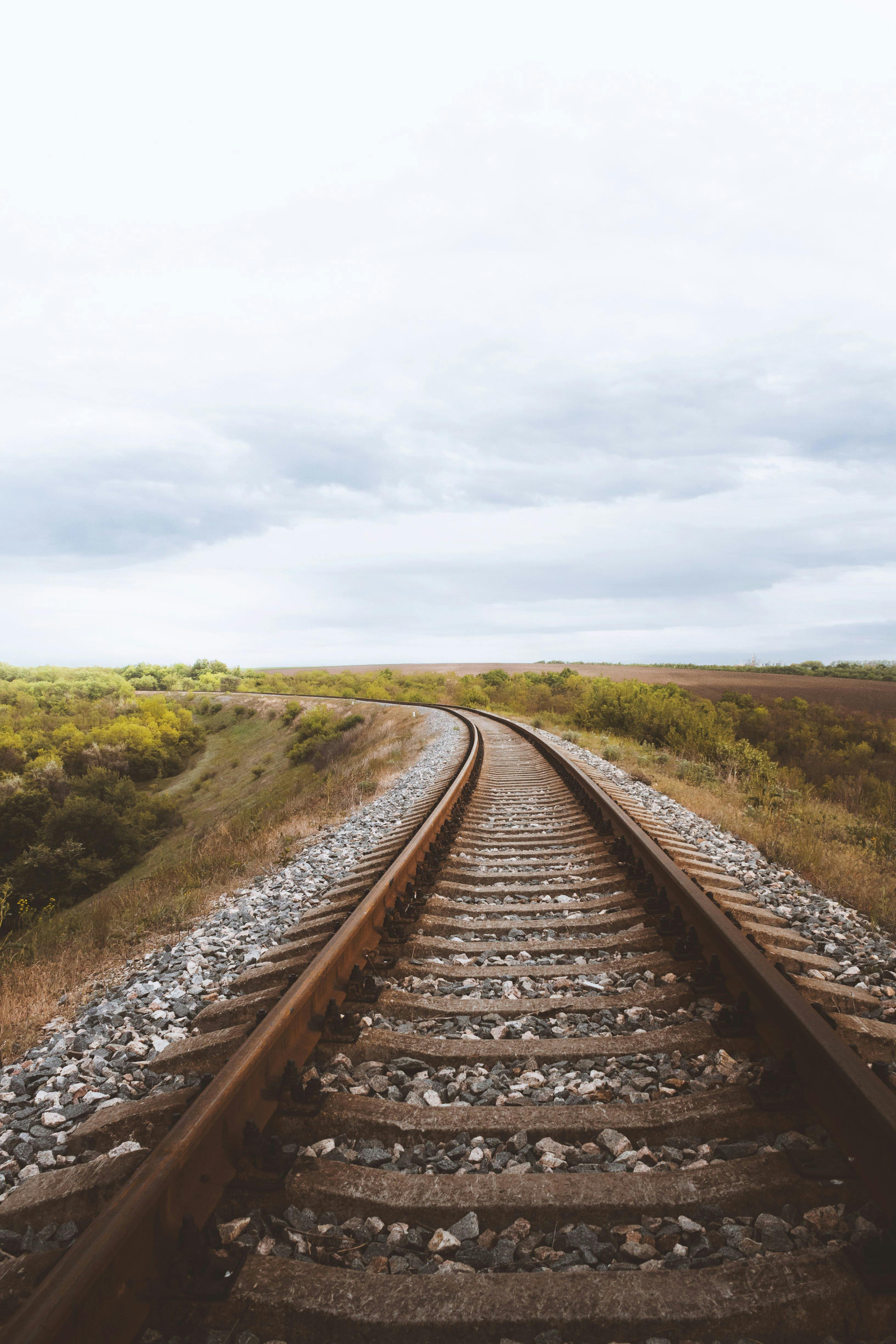 Train tracks through green forest · Free Stock Photo