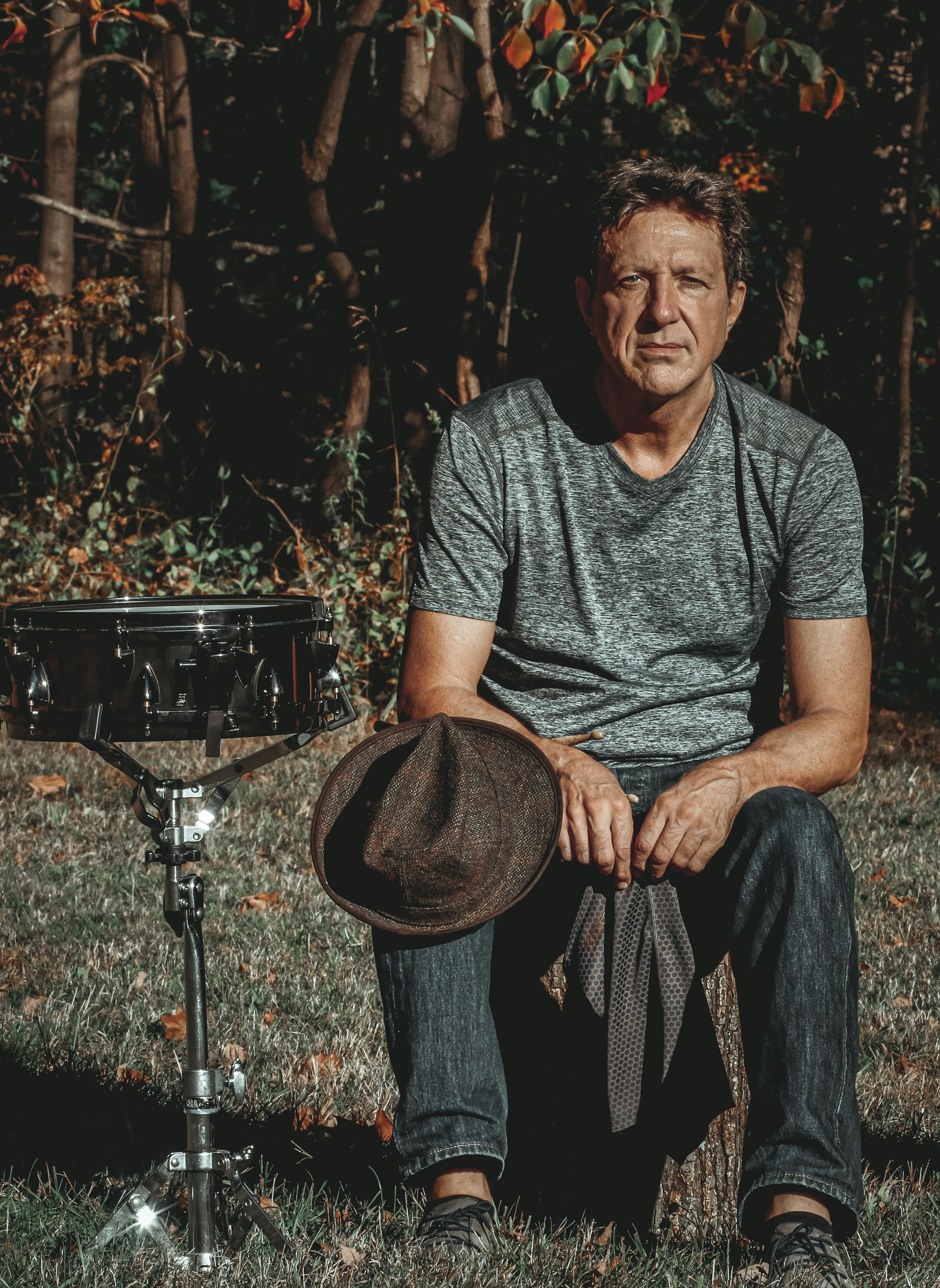 Calm male musician sitting near drum after performance in nature · Free ...