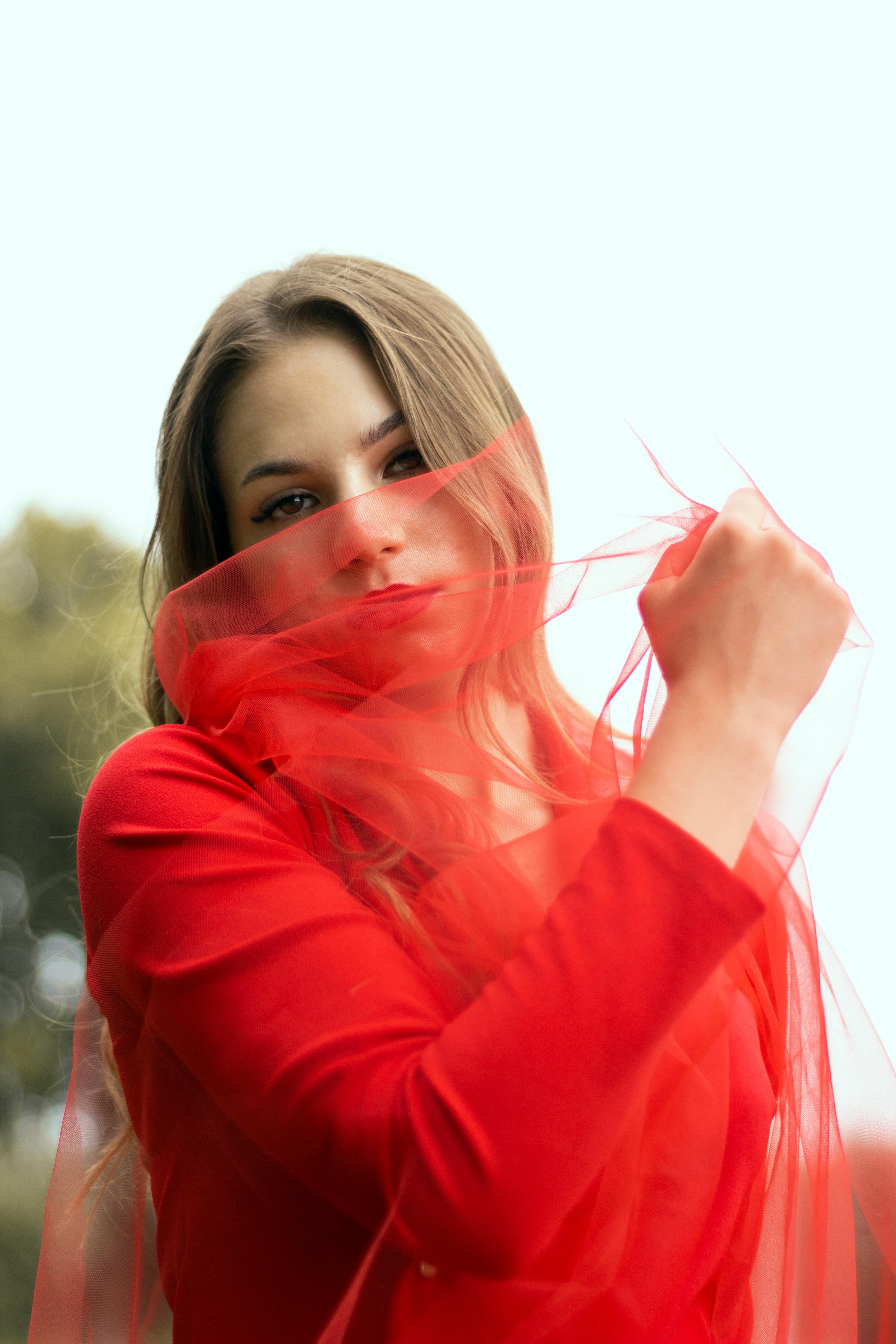 A Woman in red Ling Sleeve Shirt Holding a Red Sheer Fabric · Free ...