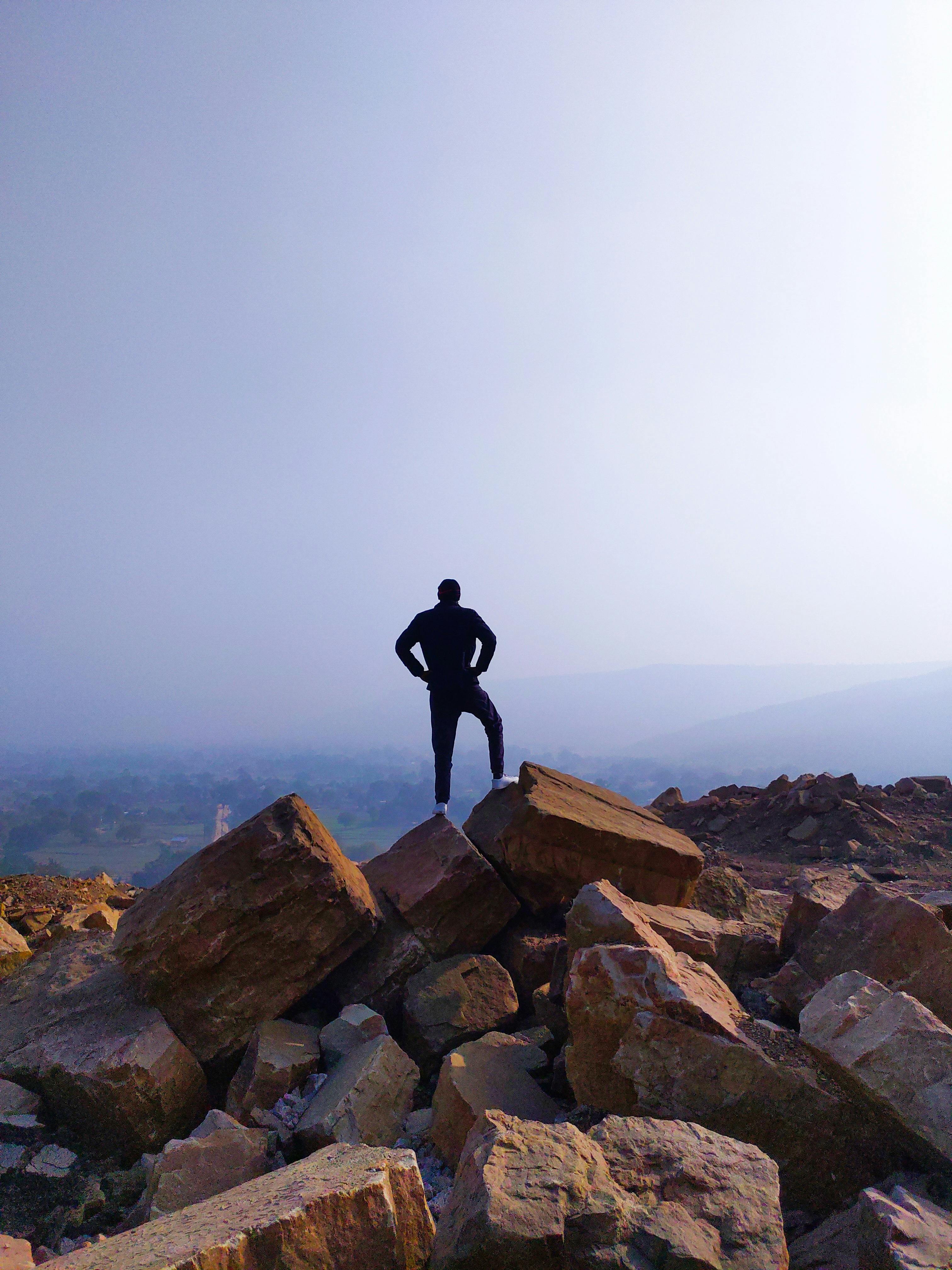 Back View of a Person Standing on Rocks · Free Stock Photo