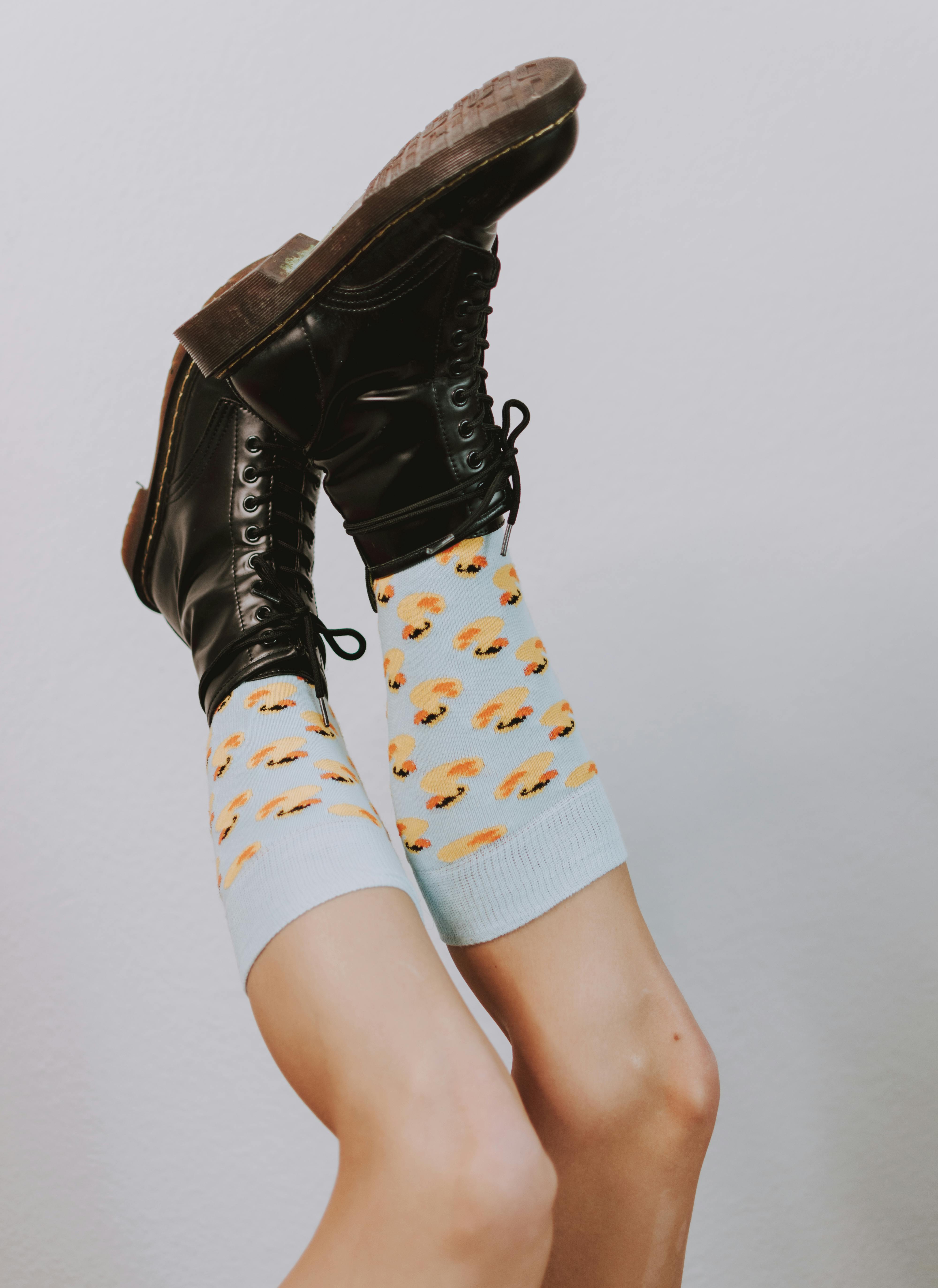 Raised legs of crop faceless person in stylish boots and socks · Free ...