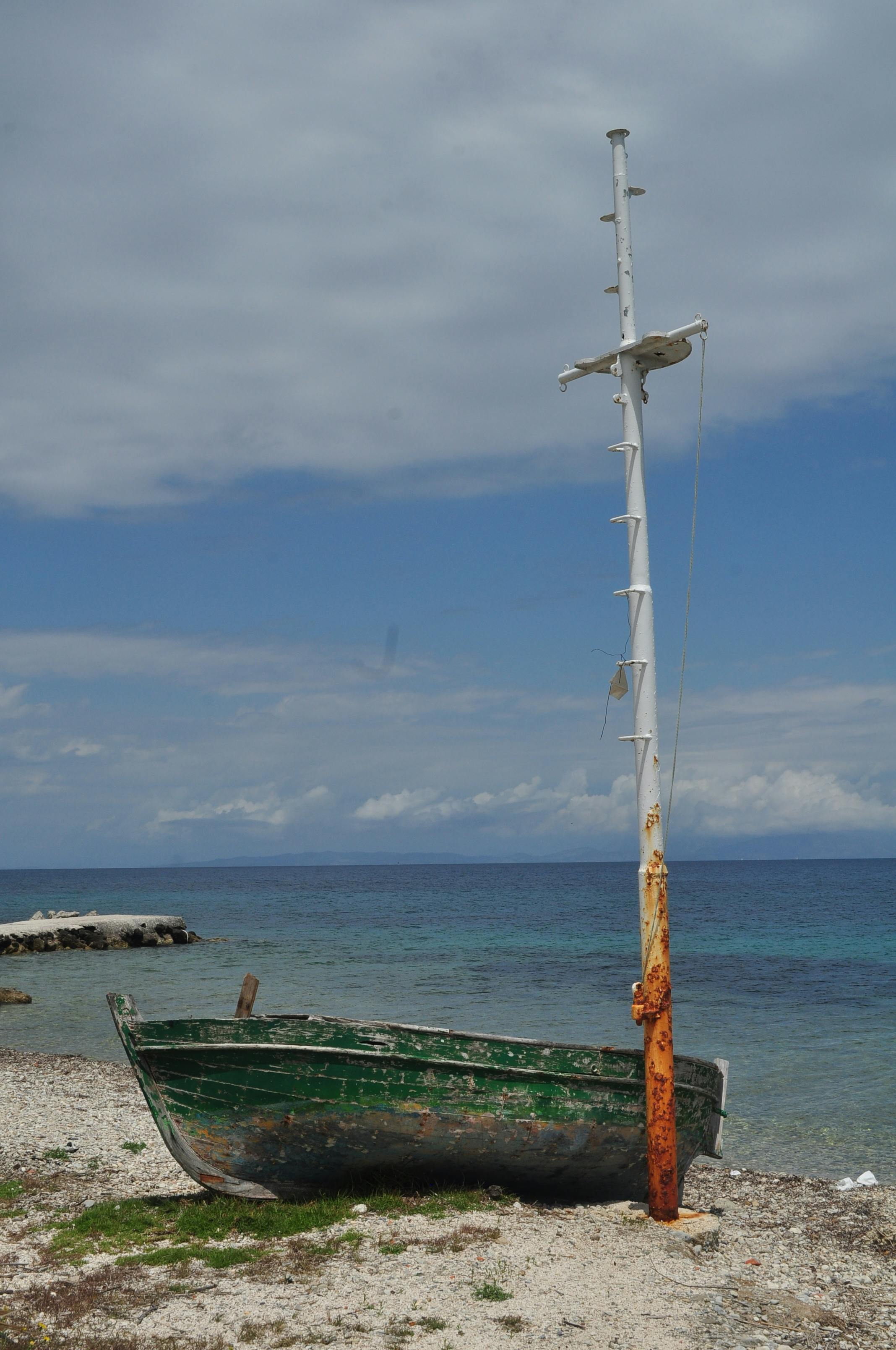 Wooden Boat Docked next to a Rusty Metal Pole · Free Stock Photo