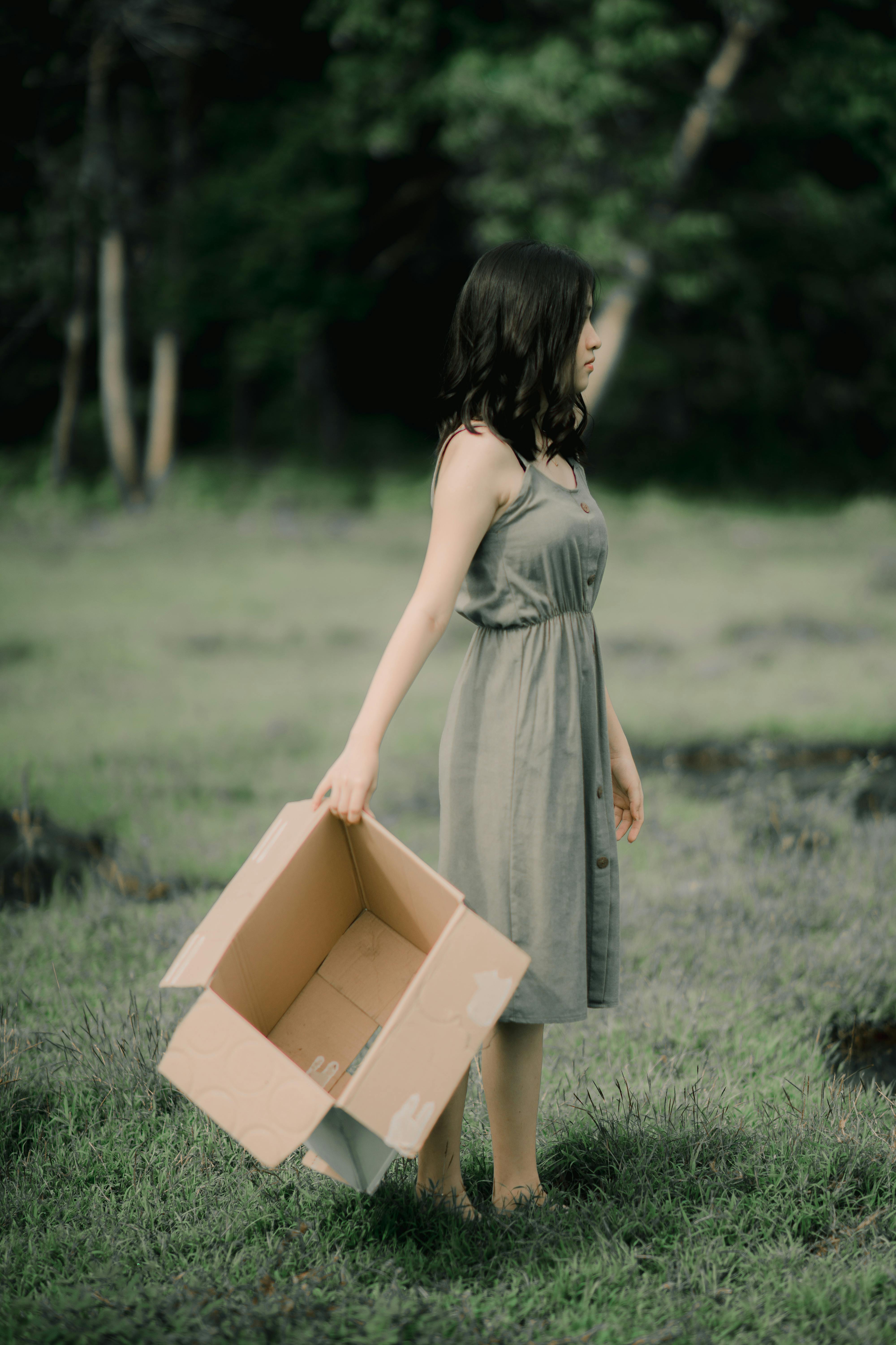 Wistful woman in dress with various balloons during festive event ...