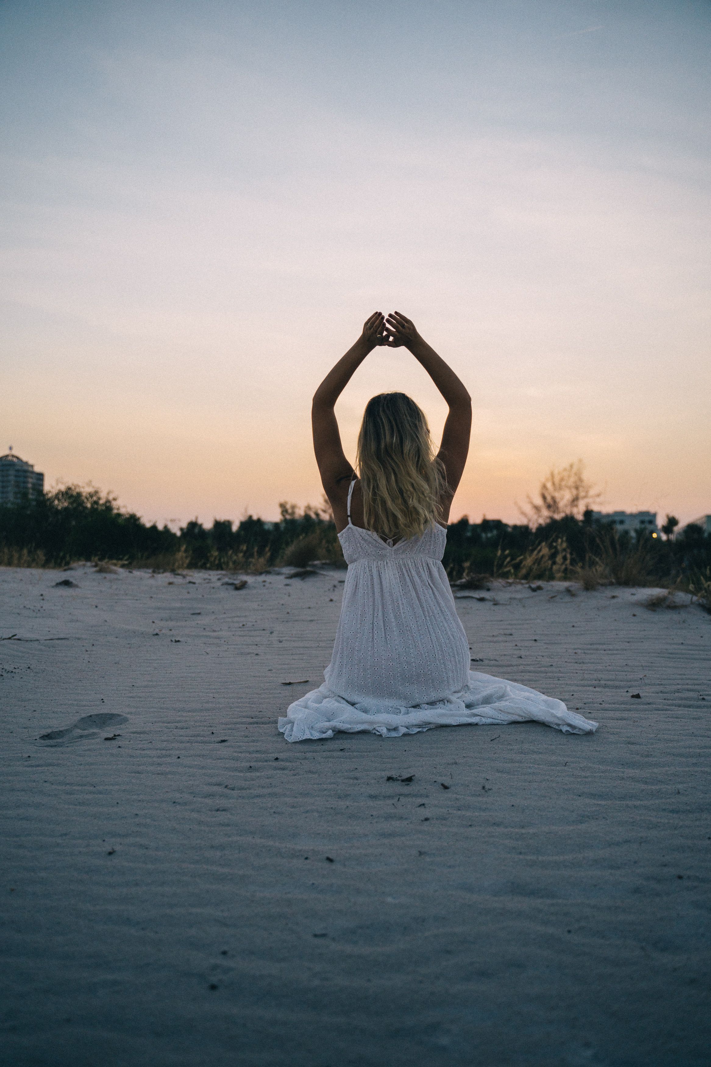 Woman in White Dress Sitting on Sand during Sunset · Free Stock Photo