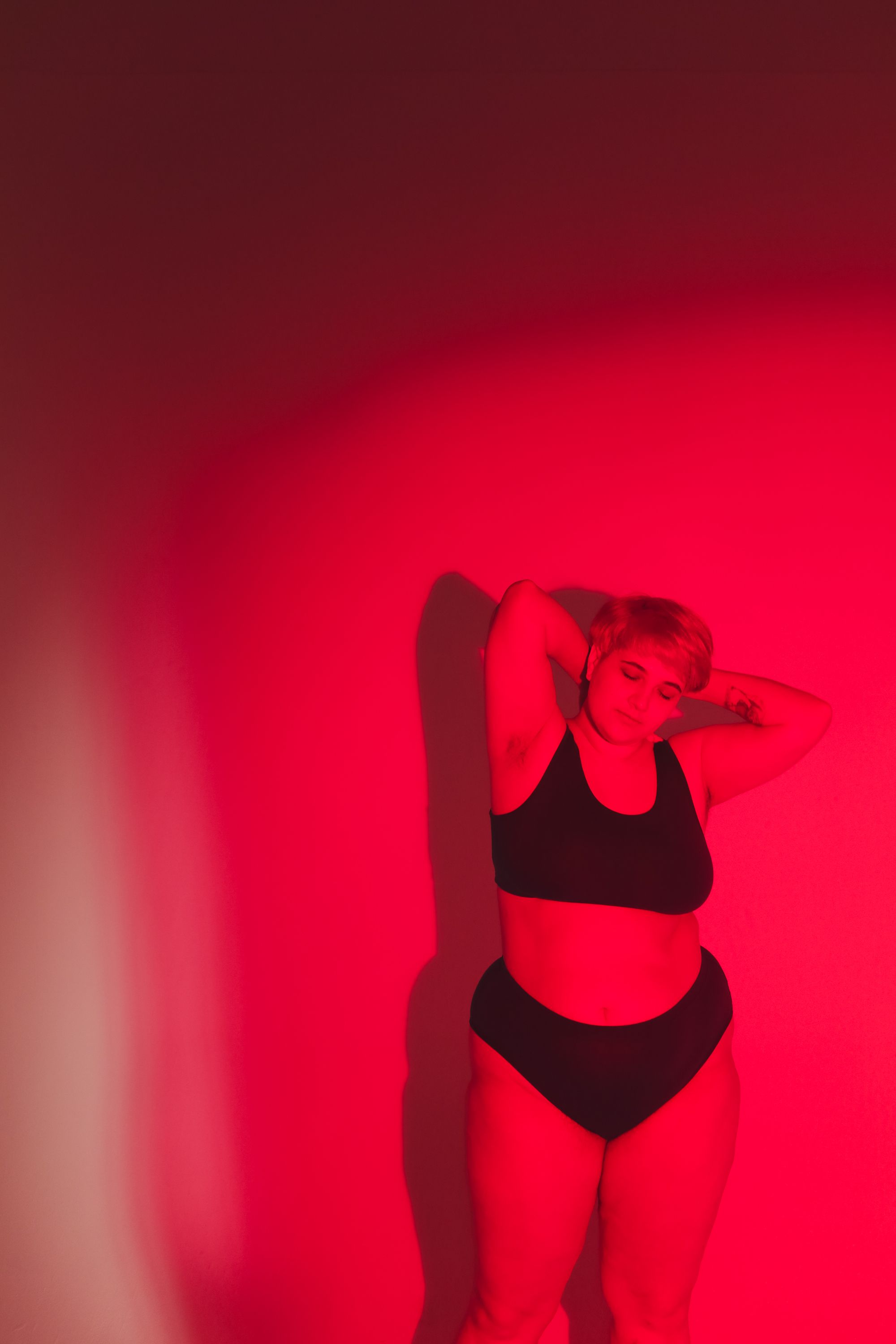 A Woman in Underwear Posing Under a Red Light · Free Stock Photo
