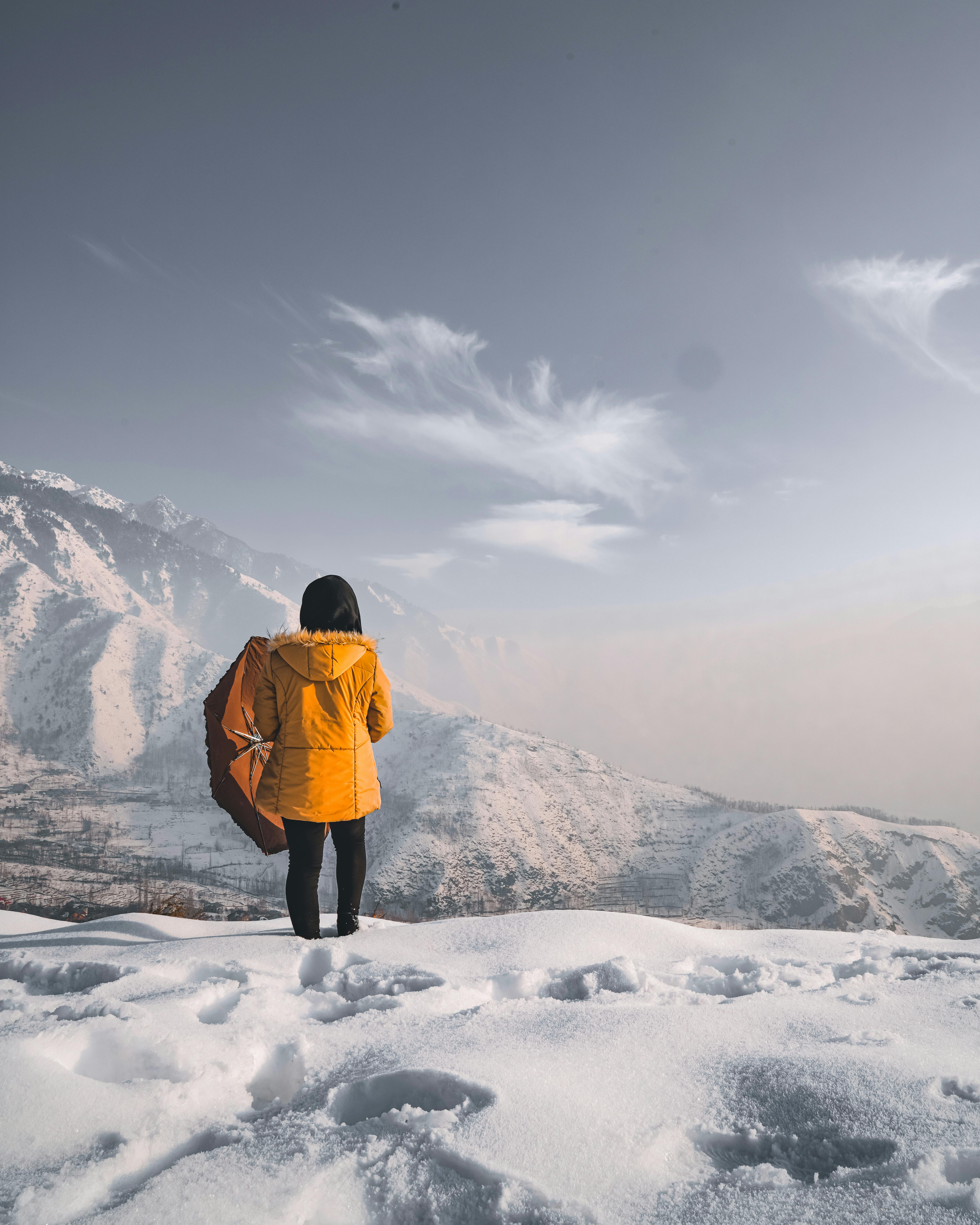 Back View of a Woman Standing on Snow Covered Ground · Free Stock Photo