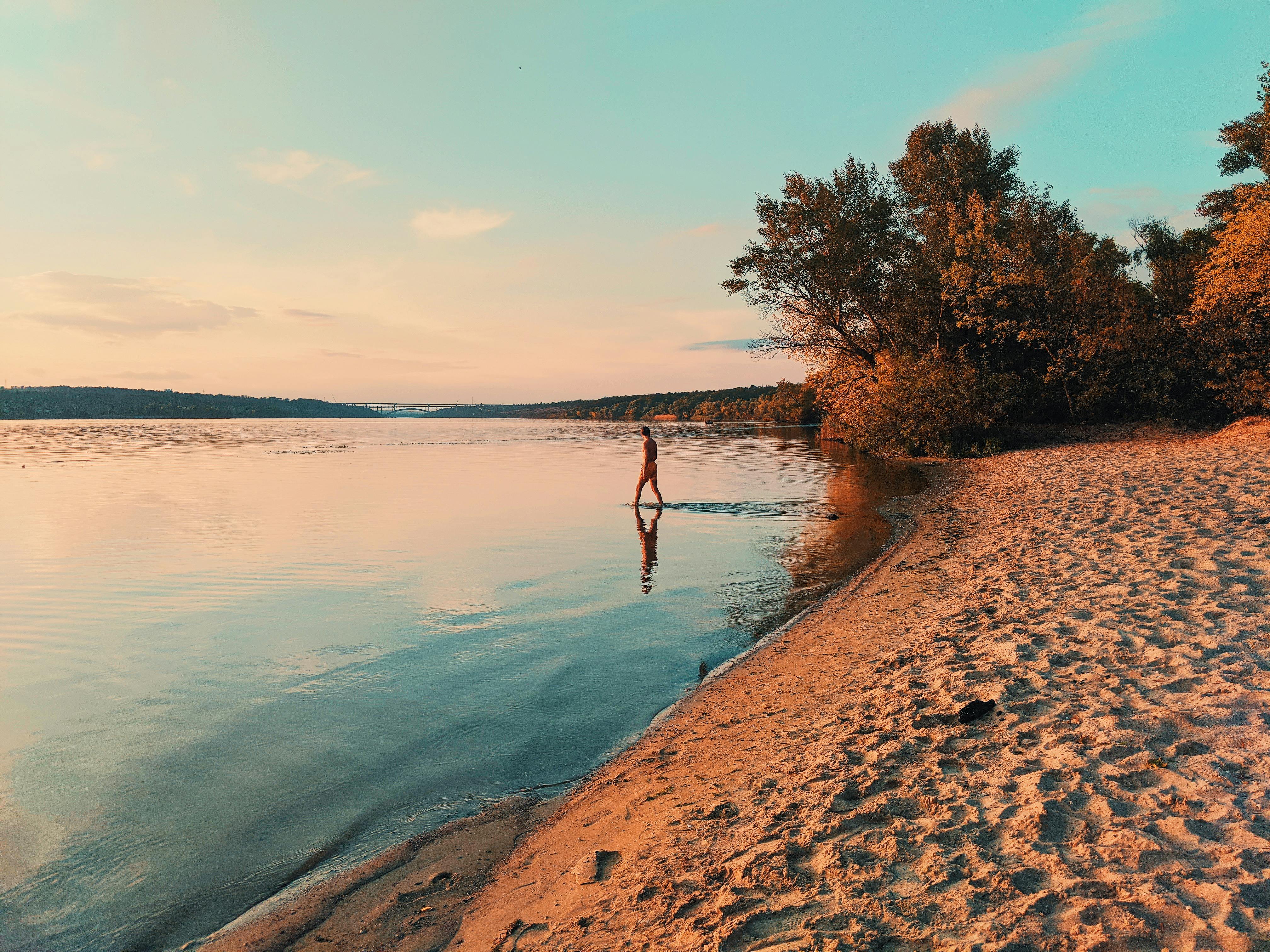 Woman in swimwear in water of lake at sunset · Free Stock Photo