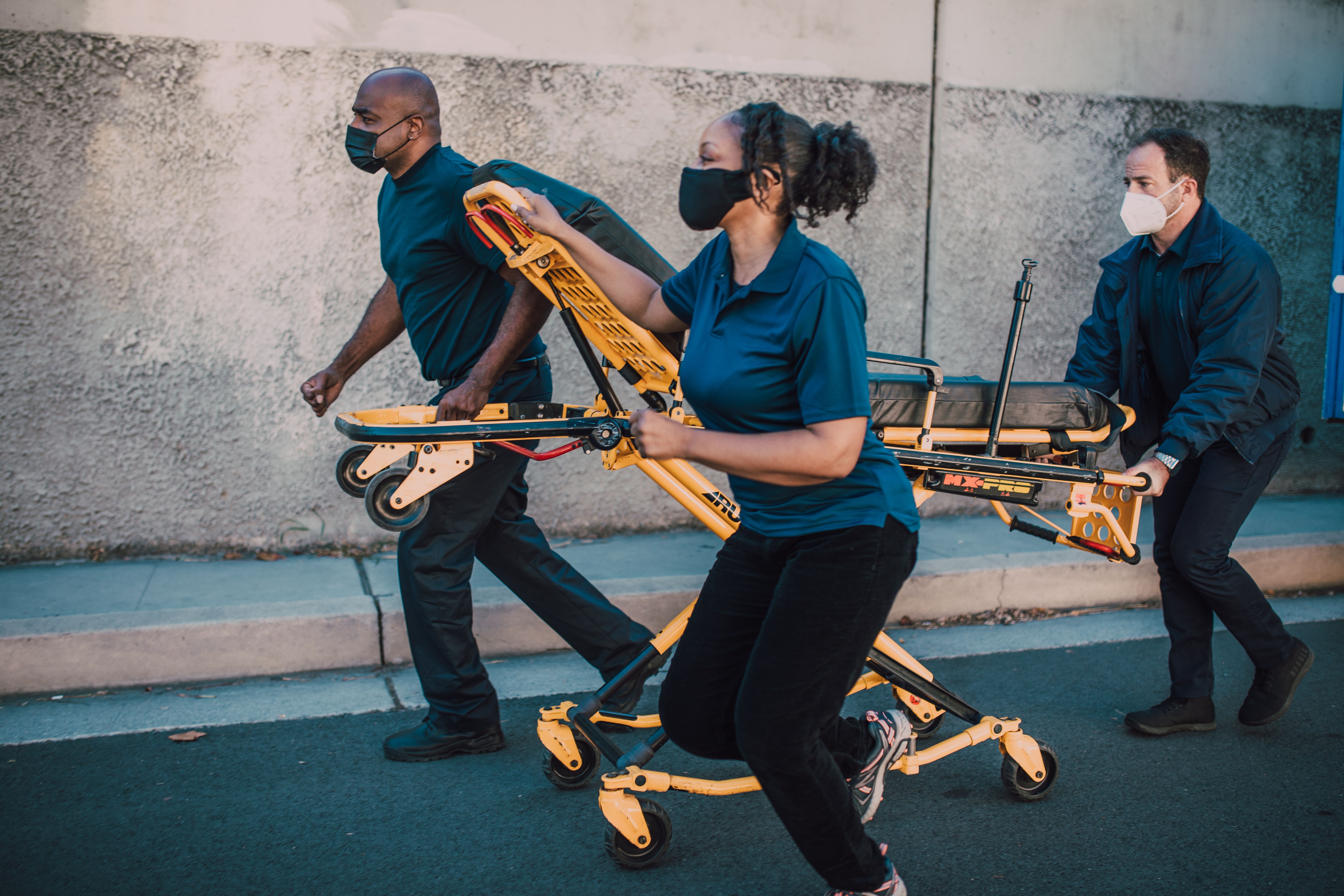 Group of Men with Helmets Holding Stretcher · Free Stock Photo