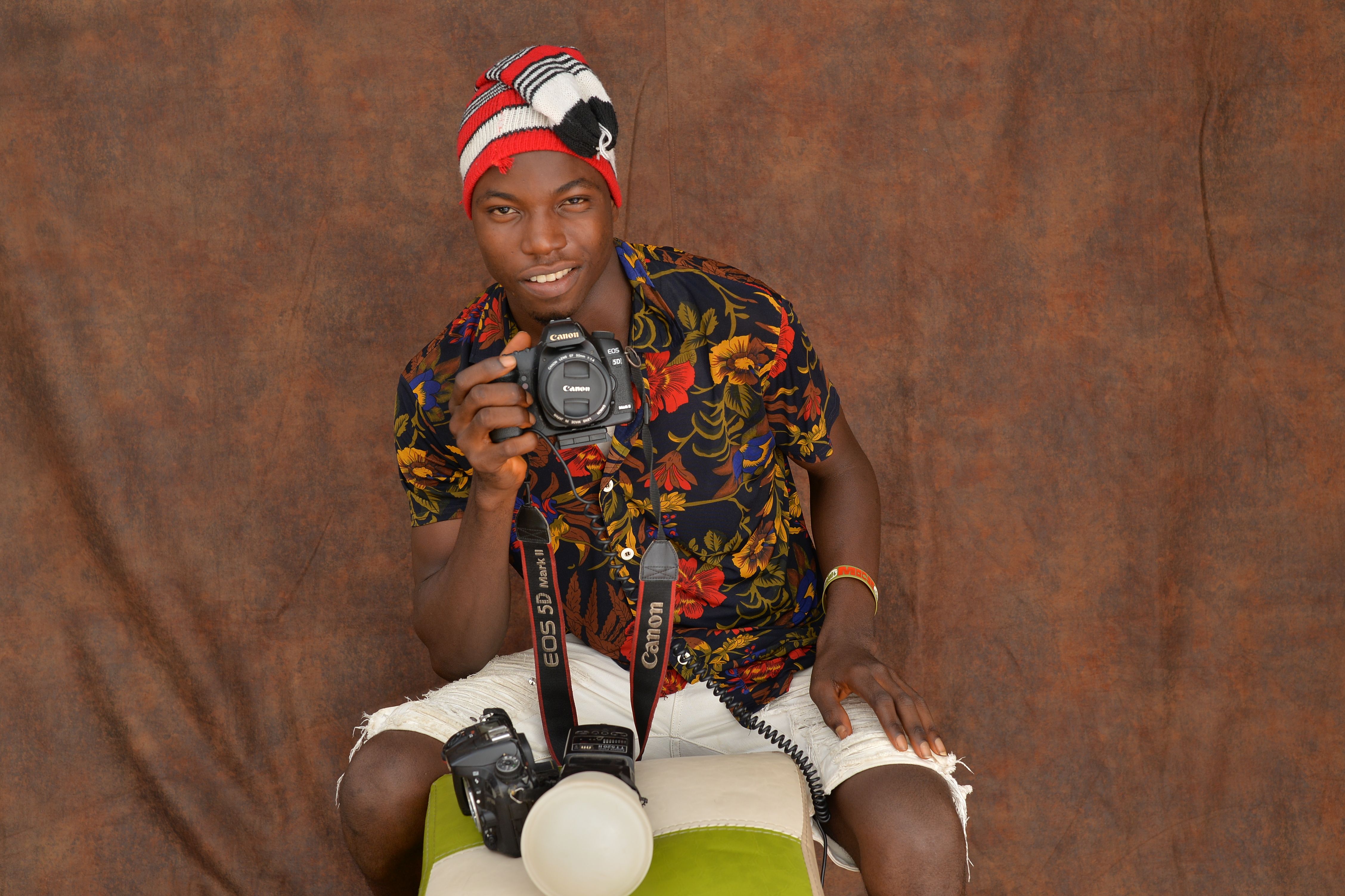 Man in Floral Polo holding a Black Camera · Free Stock Photo