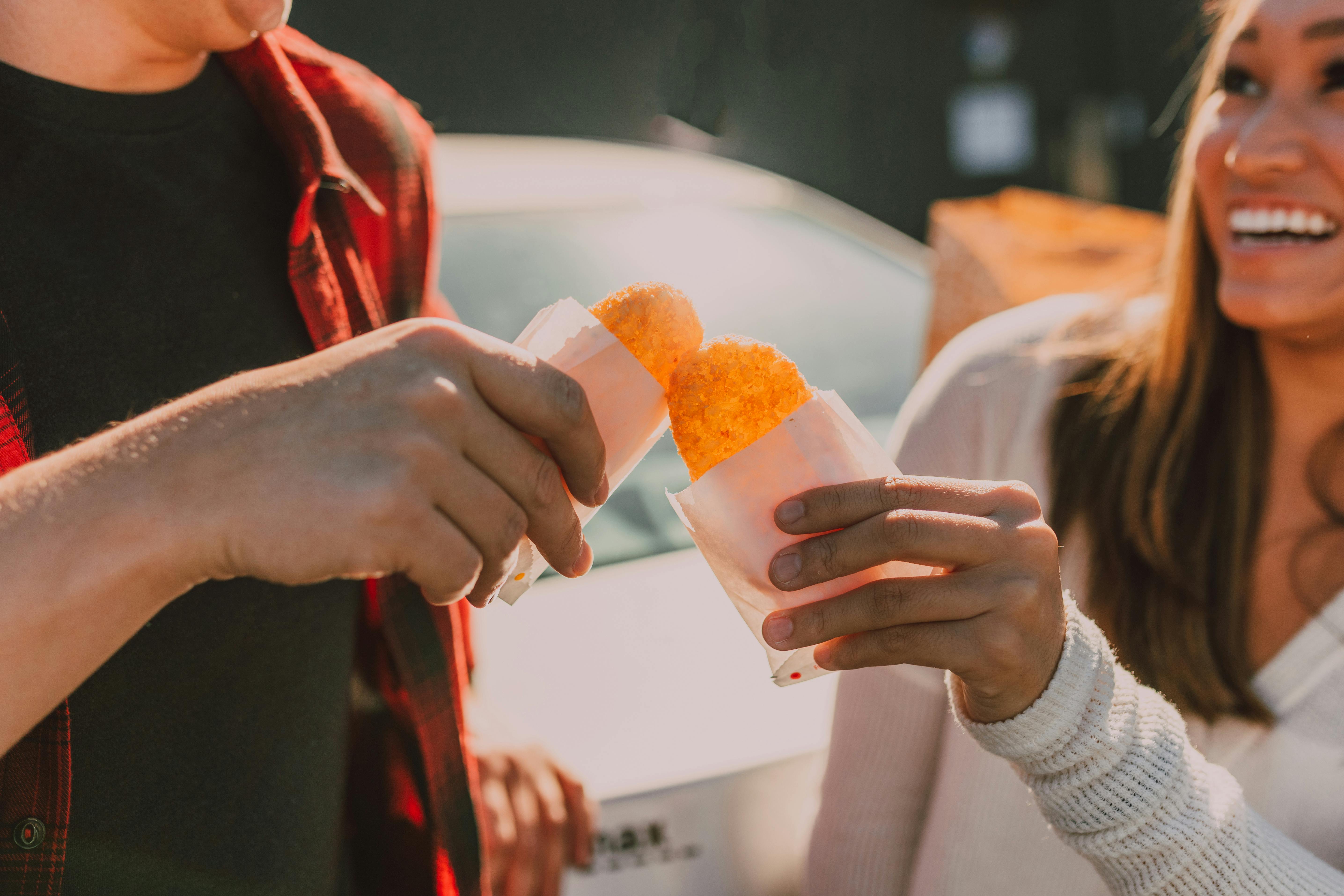 Two People holding Hash Browns · Free Stock Photo