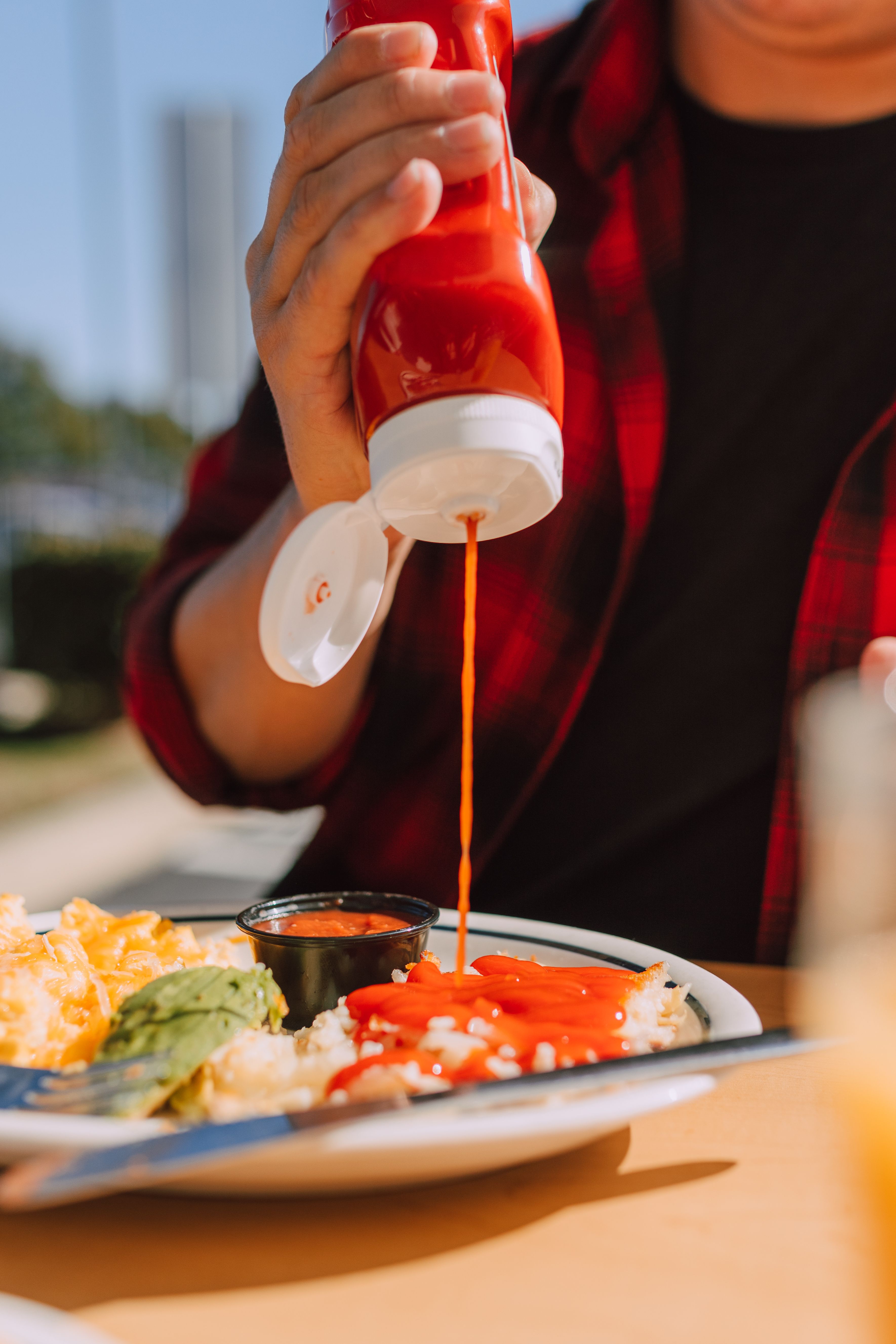 A Person Pouring Catsup on Food · Free Stock Photo