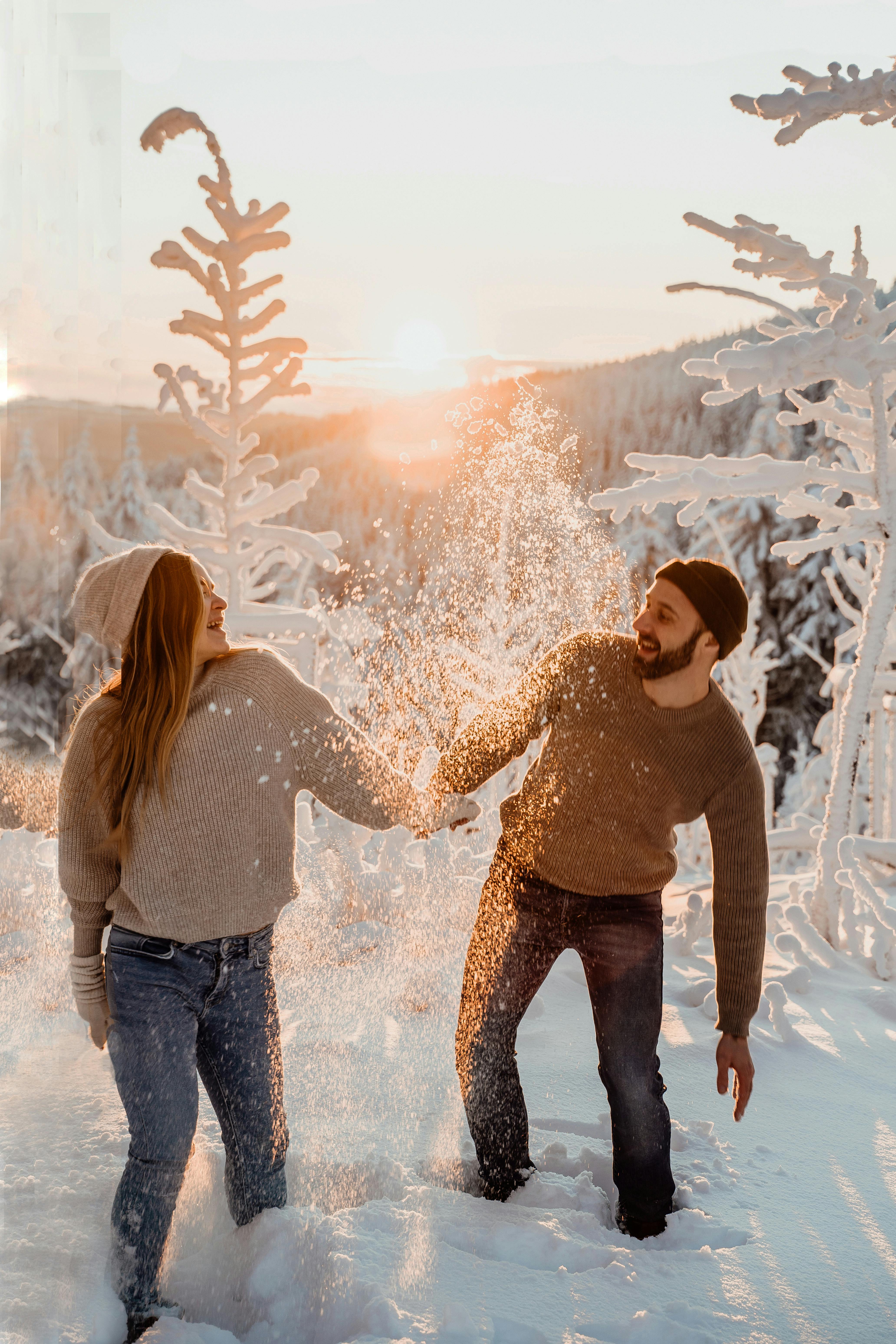 A Couple Playing with Snow on a Snow Covered Ground · Free Stock Photo