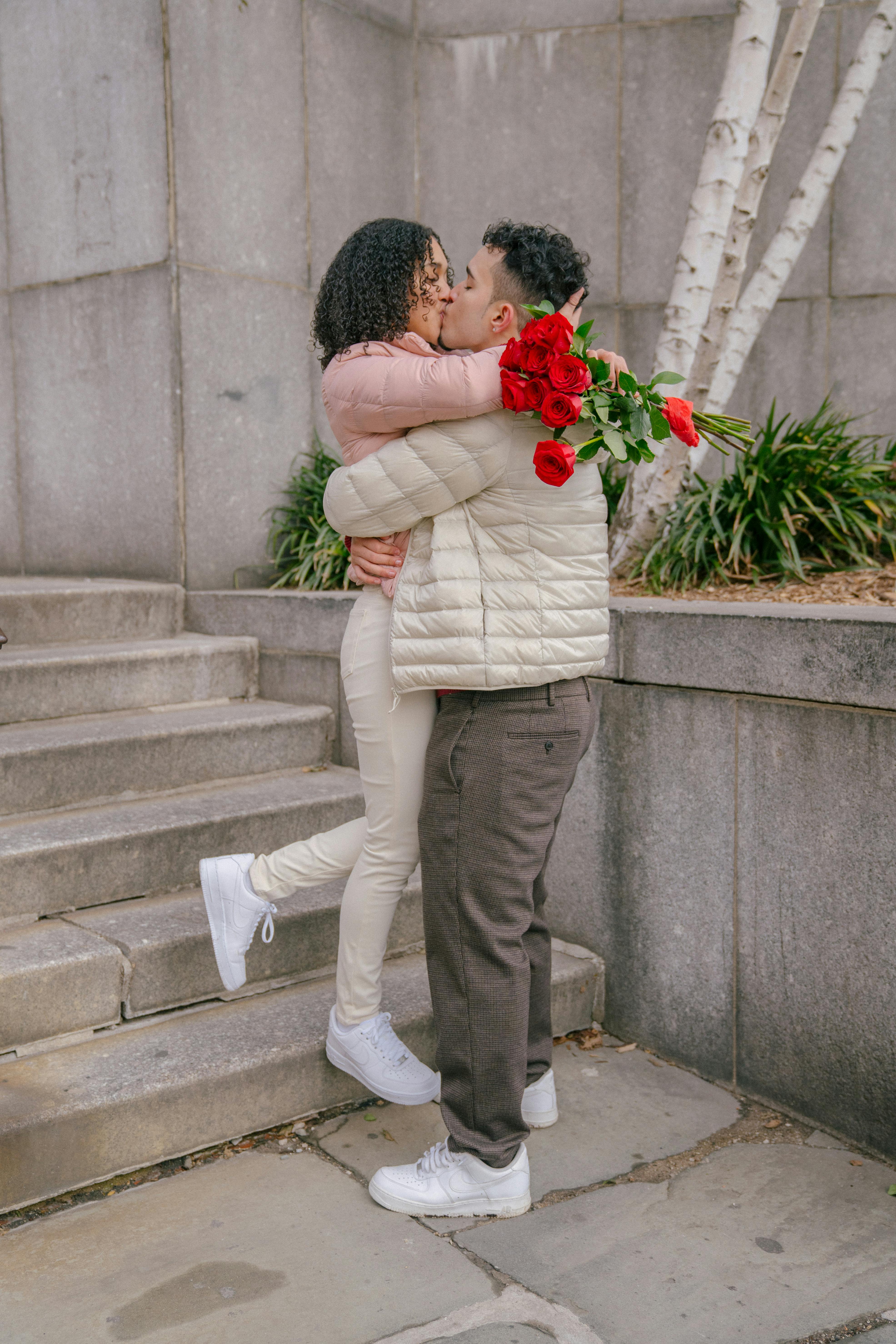 Amorous young Hispanic couple cuddling and kissing during date · Free ...