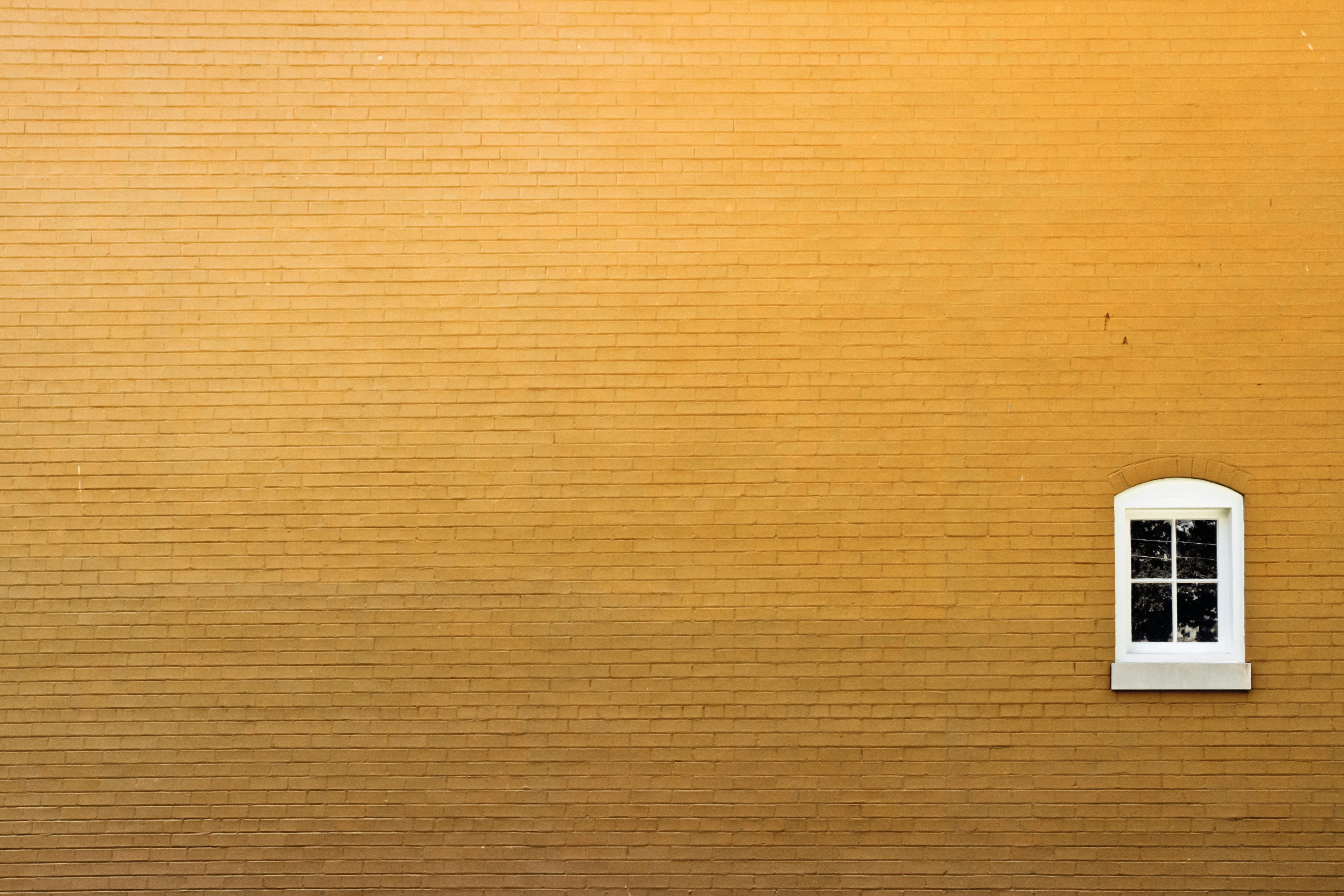 A Glass Window on a Yellow Brick Wall · Free Stock Photo