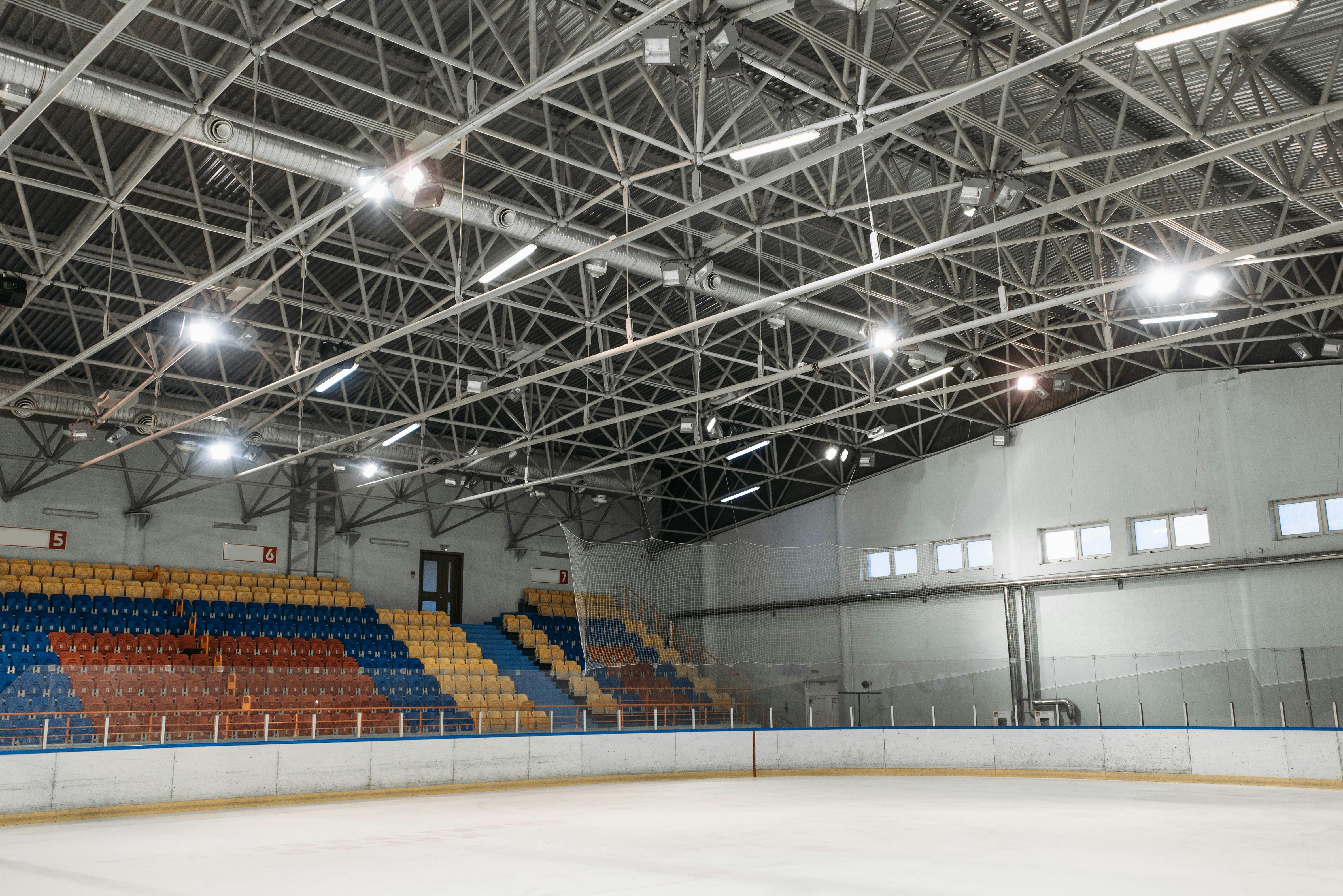 An Ice Rink with Lights Hanging on Steel Bars · Free Stock Photo
