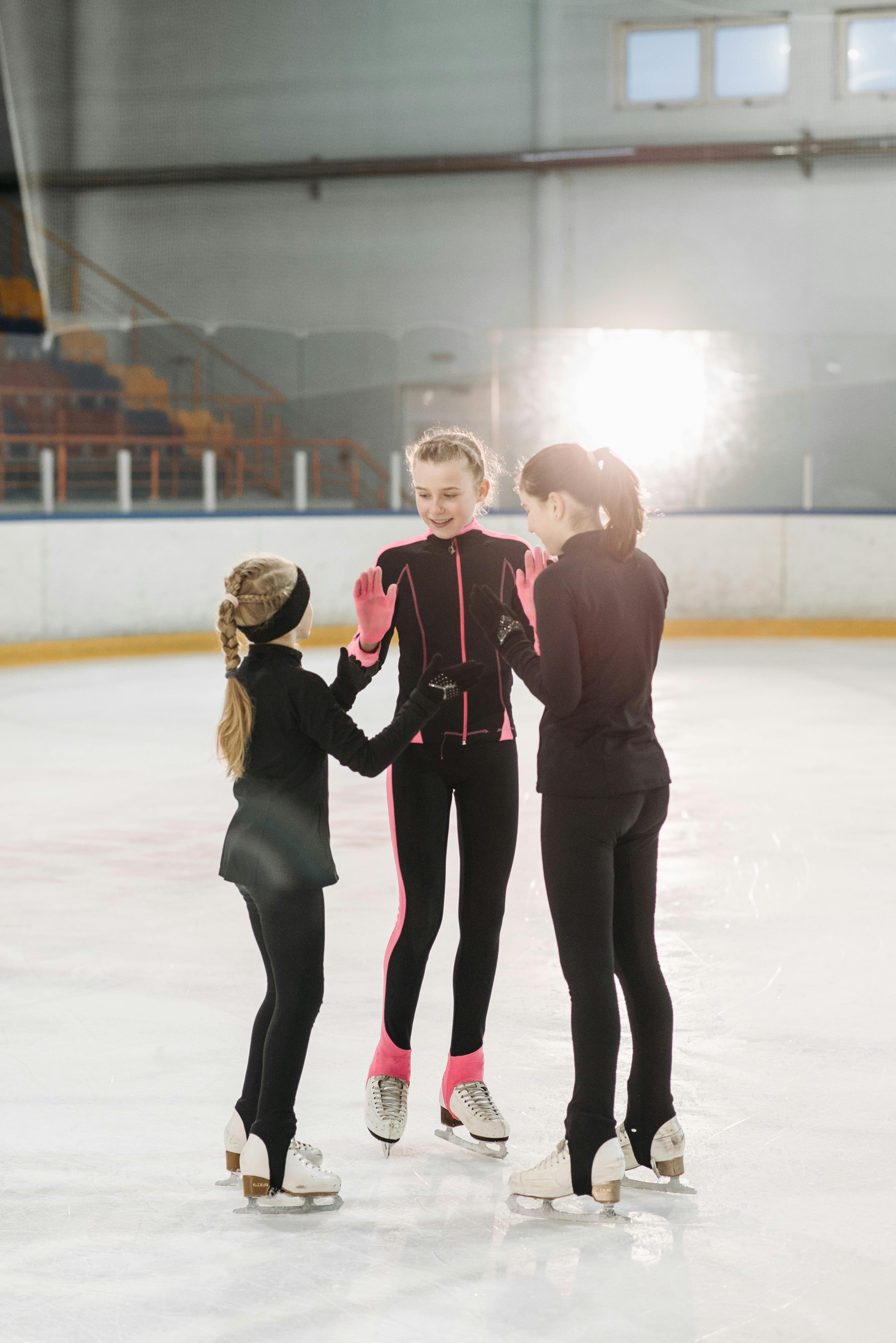 Girls Wearing ice Skates Giving Each Other a High Five · Free Stock Photo