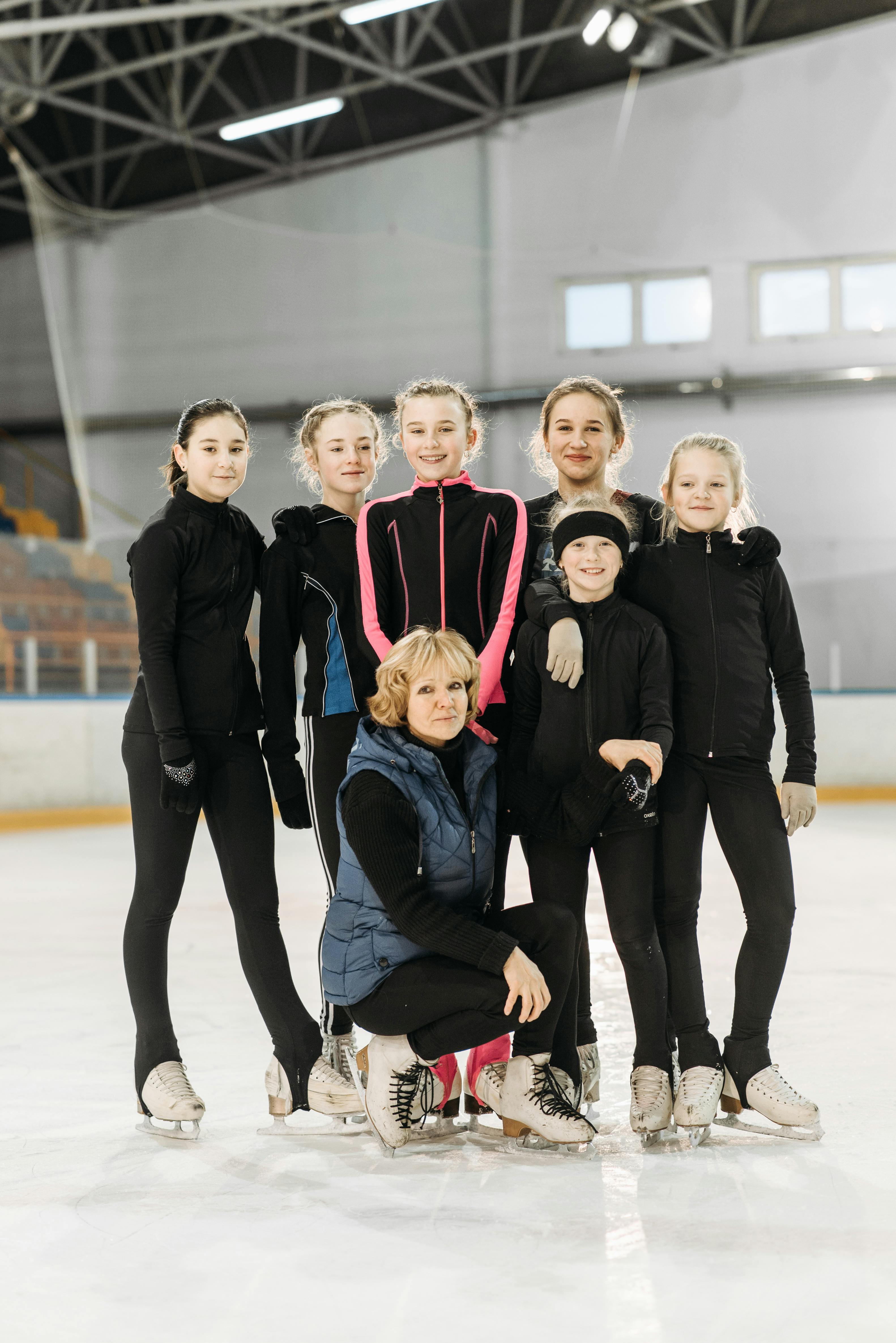 A Woman with a Group of Young Women and Girls Wearing Ice Skates · Free ...