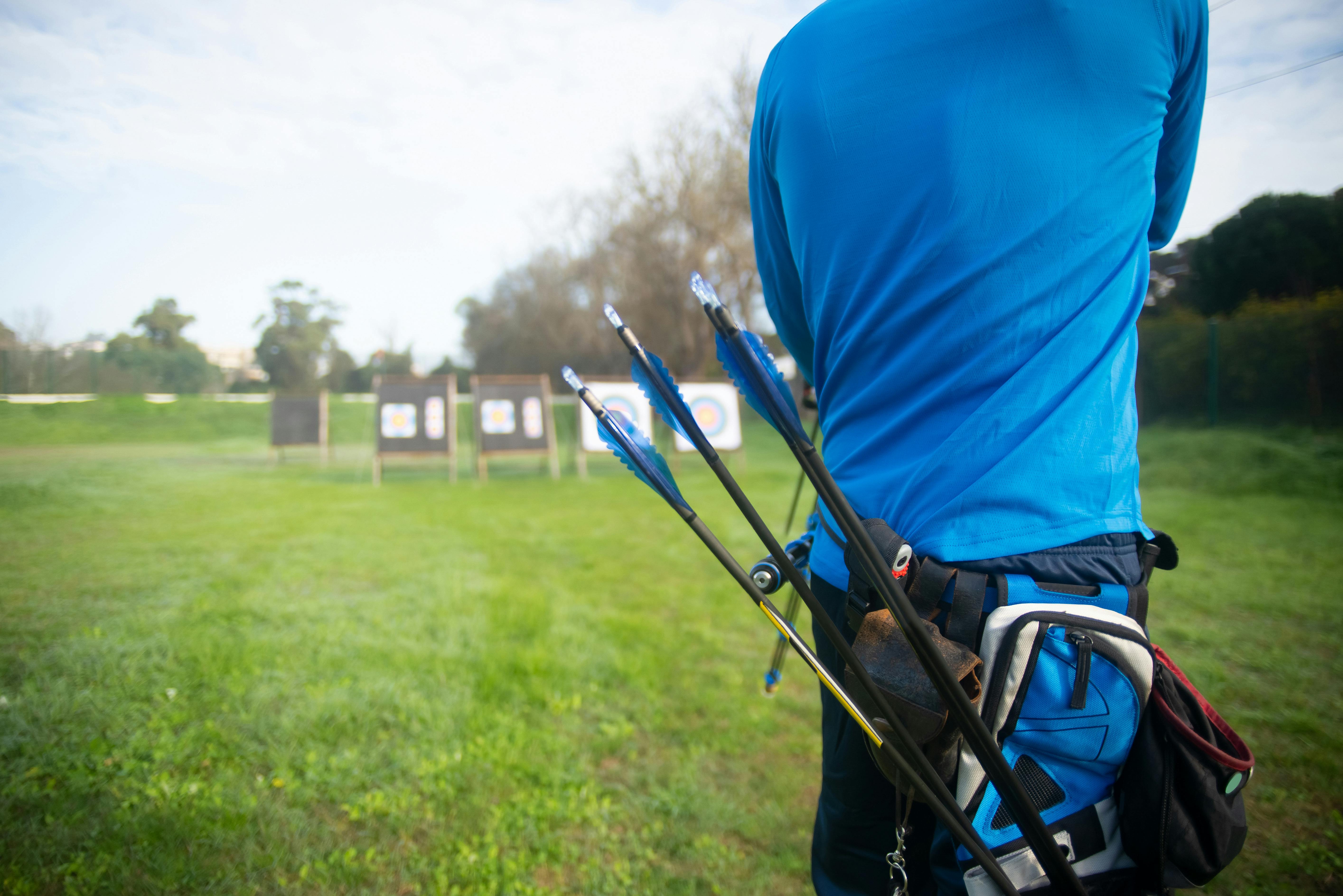 Person in Blue Shirt Carrying Quiver with Arrows · Free Stock Photo