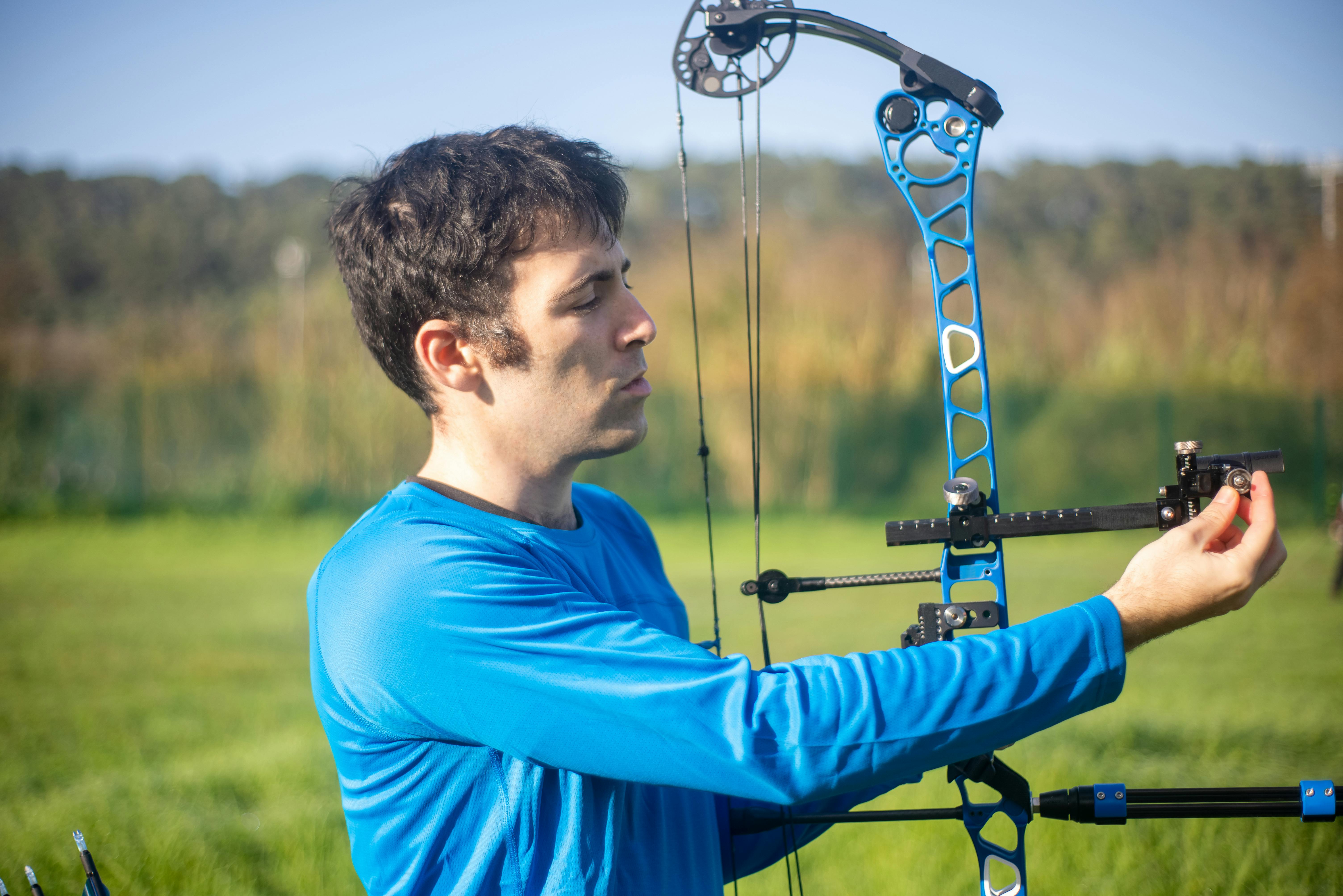 Man Holding Compound Bow Equipment · Free Stock Photo