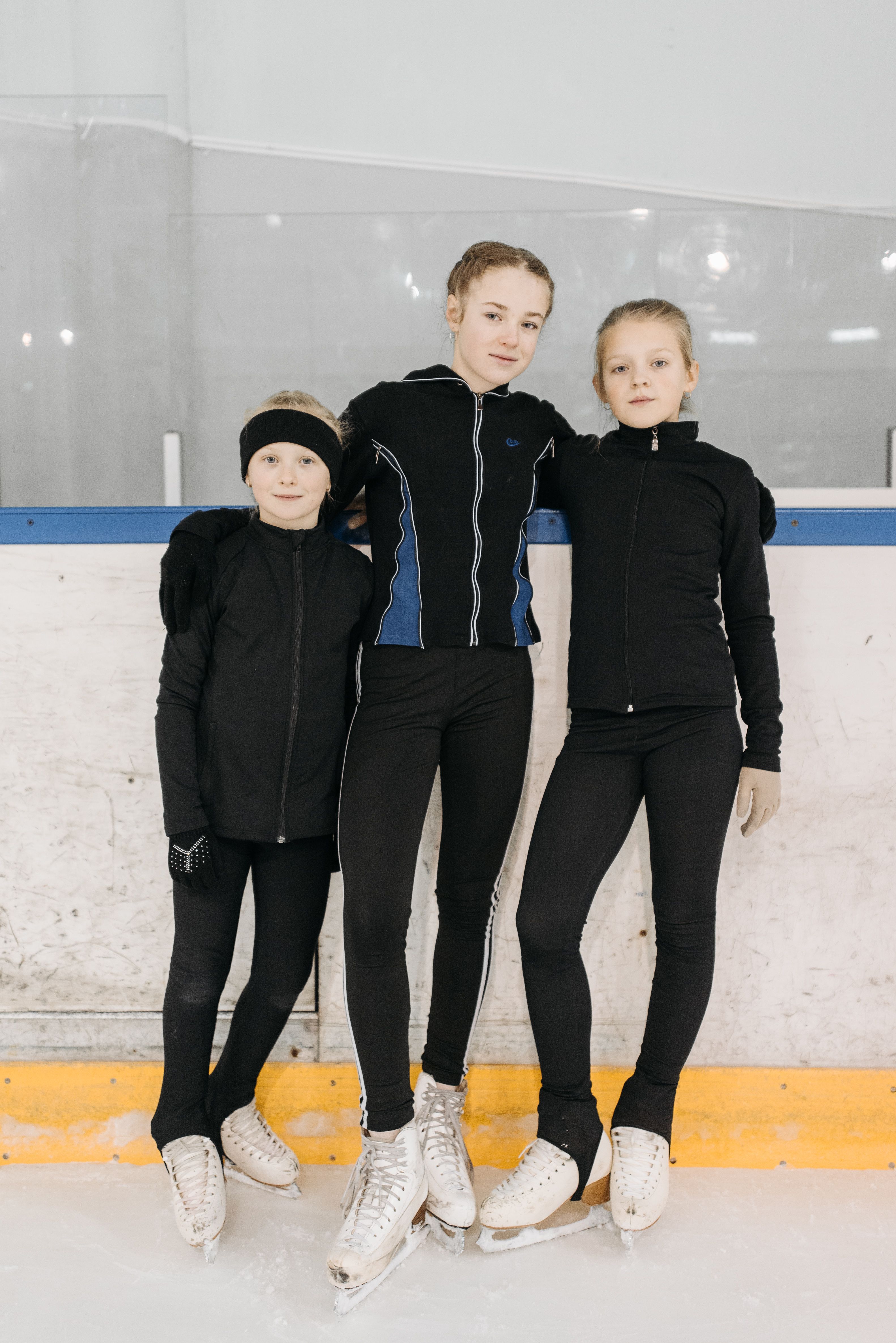 Girls Wearing Ice Skates Standing Beside a Wall · Free Stock Photo