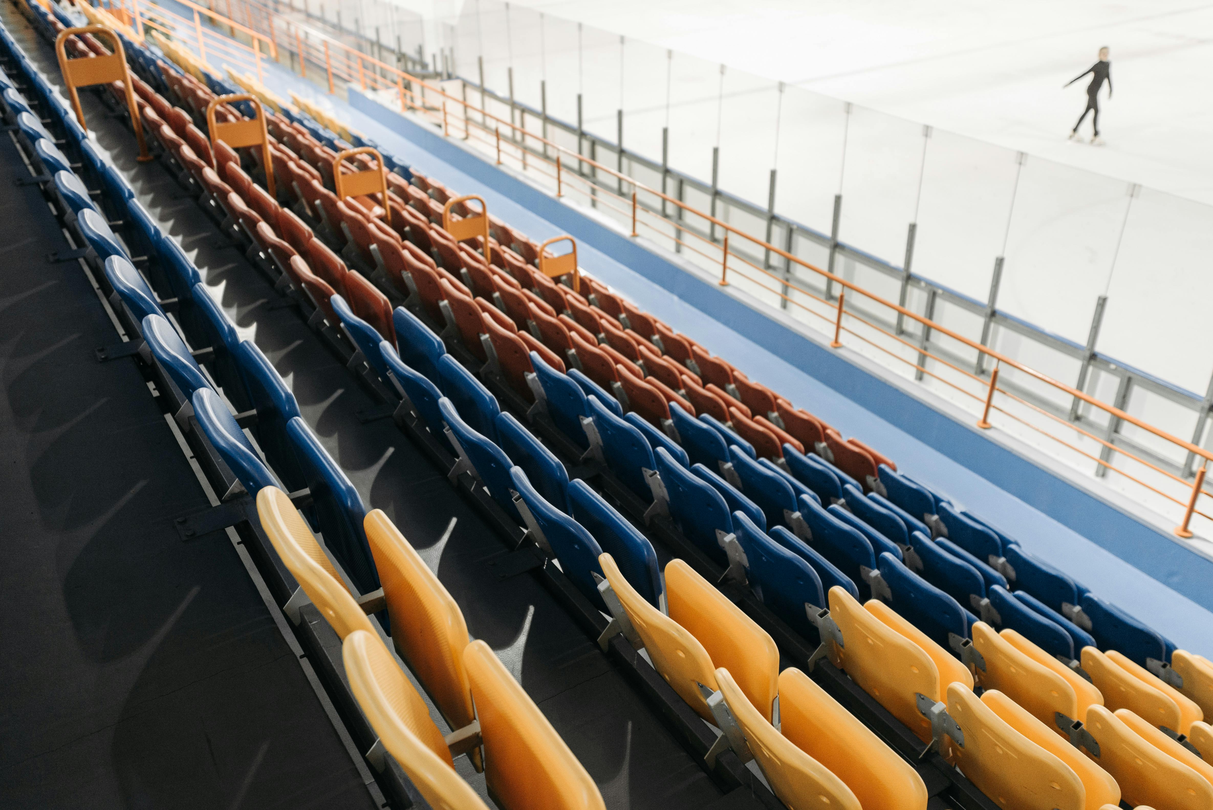 A Person Ice Skating on a Stadium with Empty Bleachers · Free Stock Photo